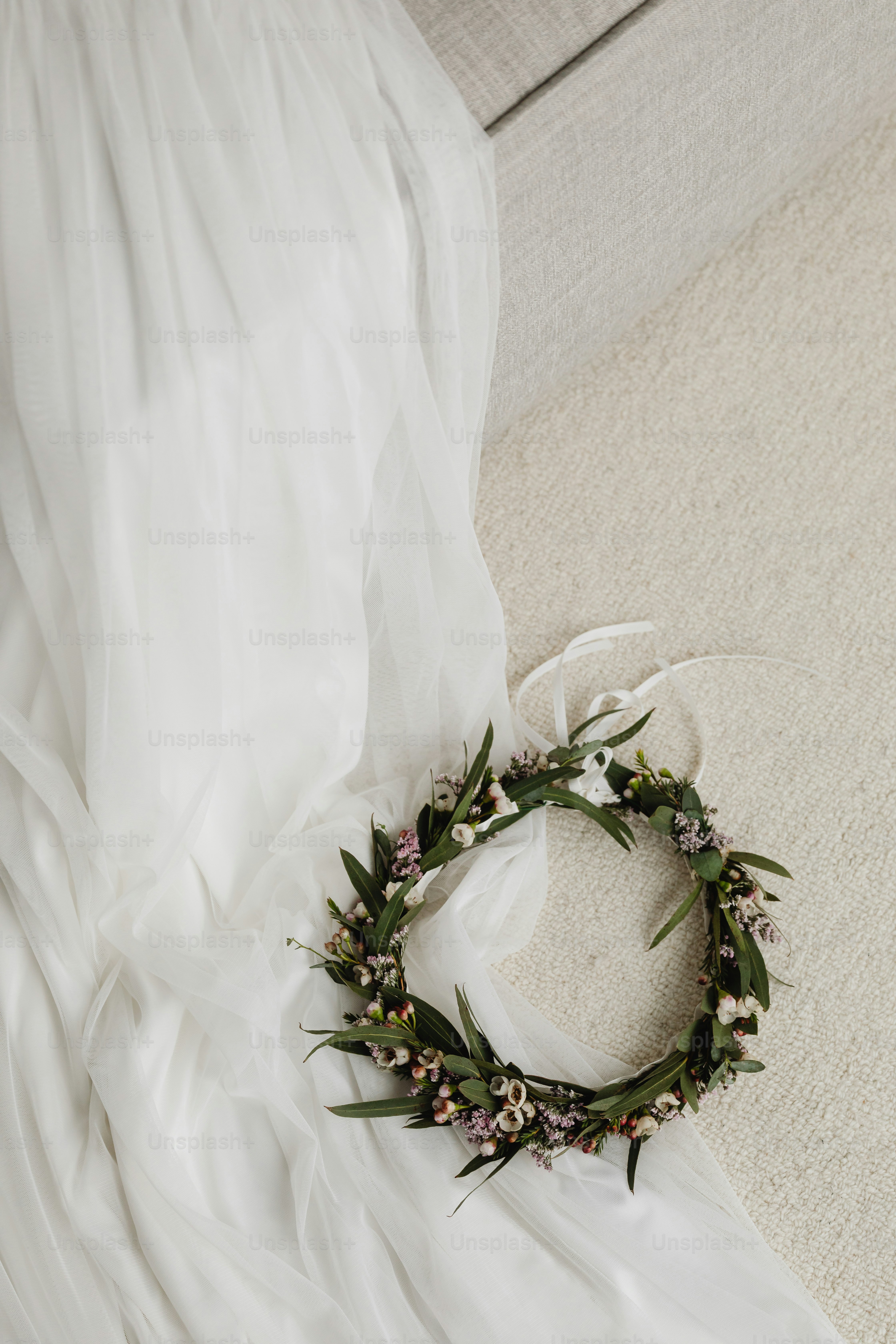 A flower crown laying on the floor next to a bed photo – Wedding Image ...