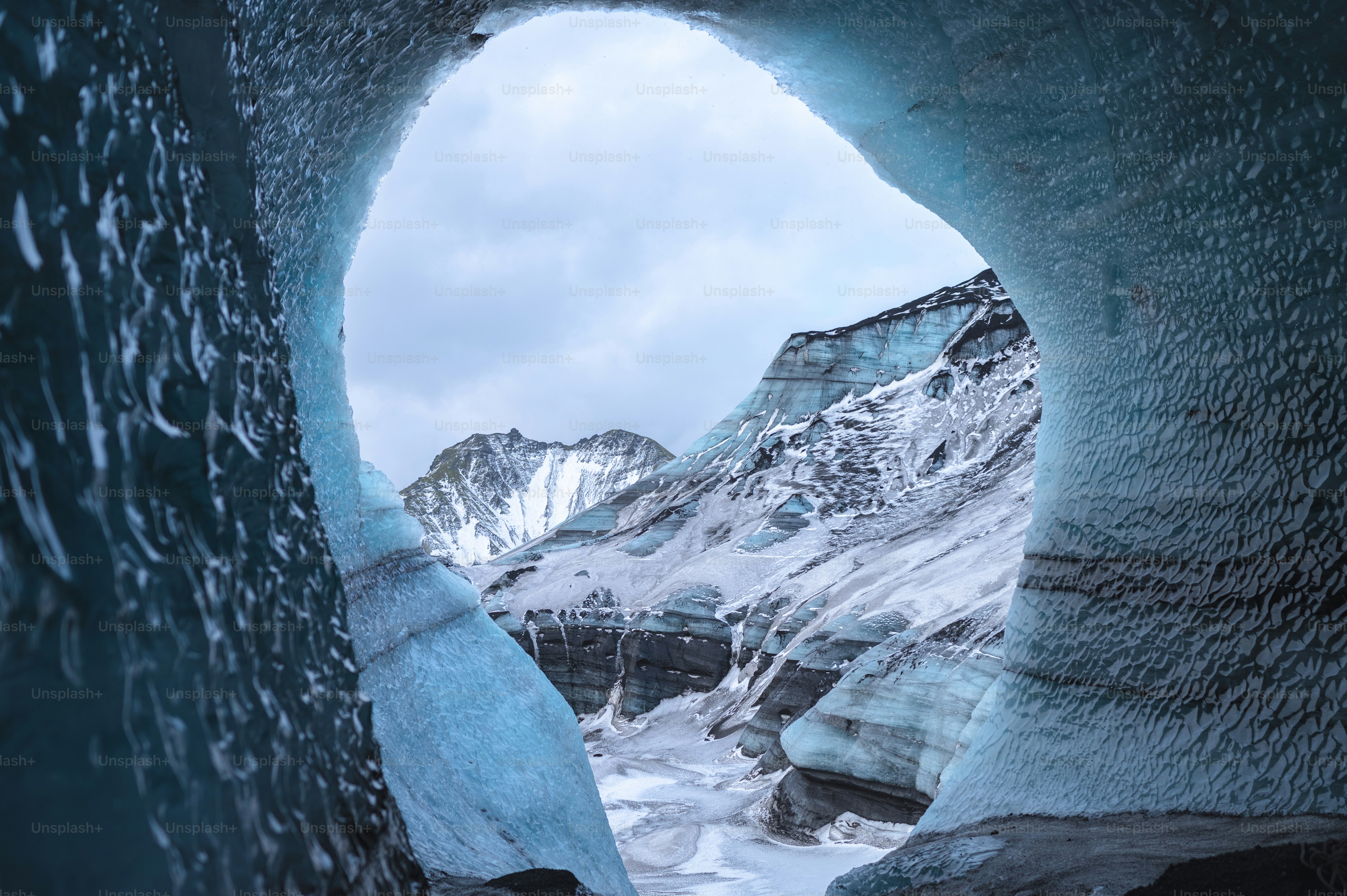 A large ice cave with a mountain in the background photo – Nature Image ...