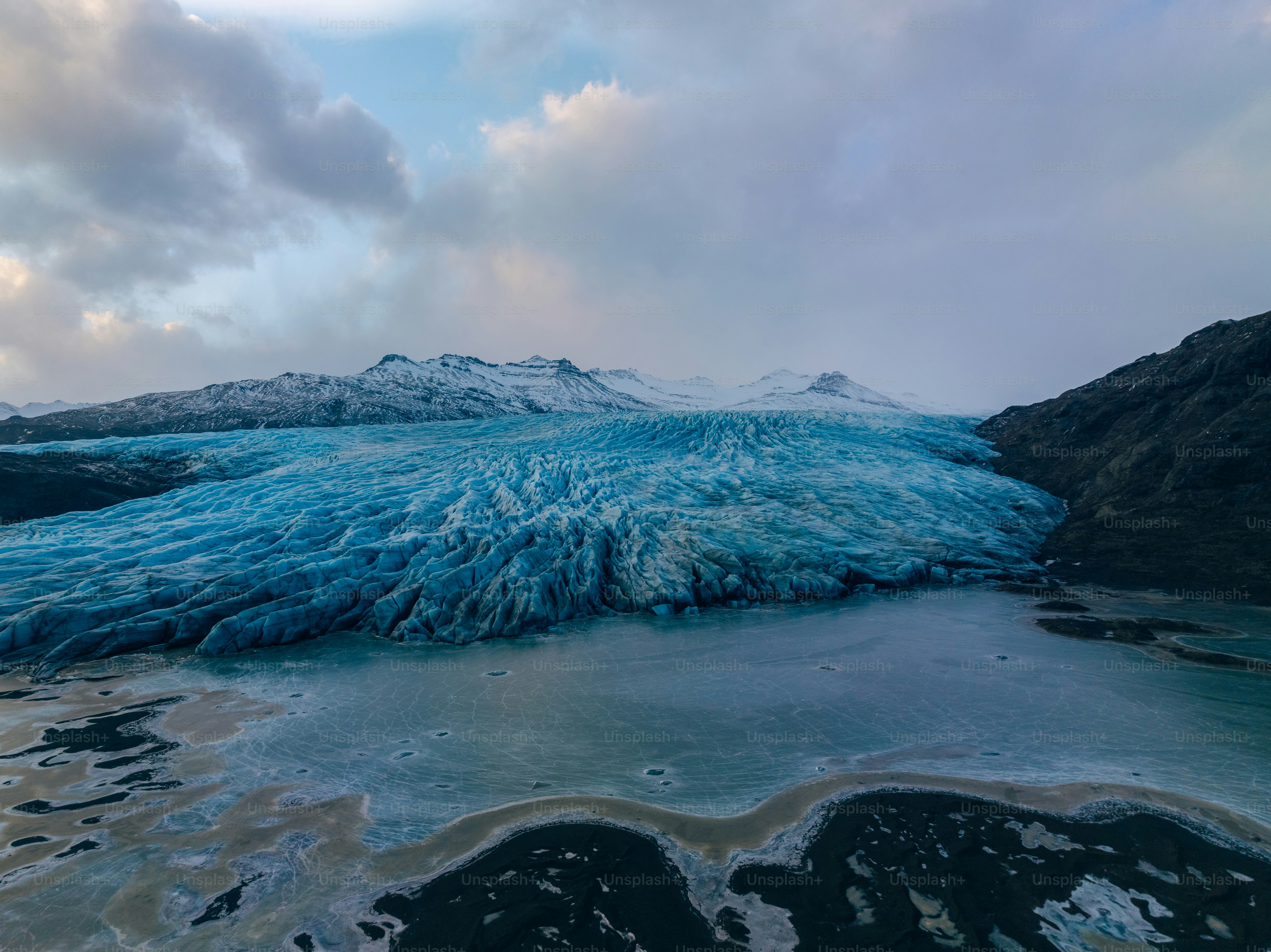 A very large ice covered mountain in the middle of the ocean photo ...