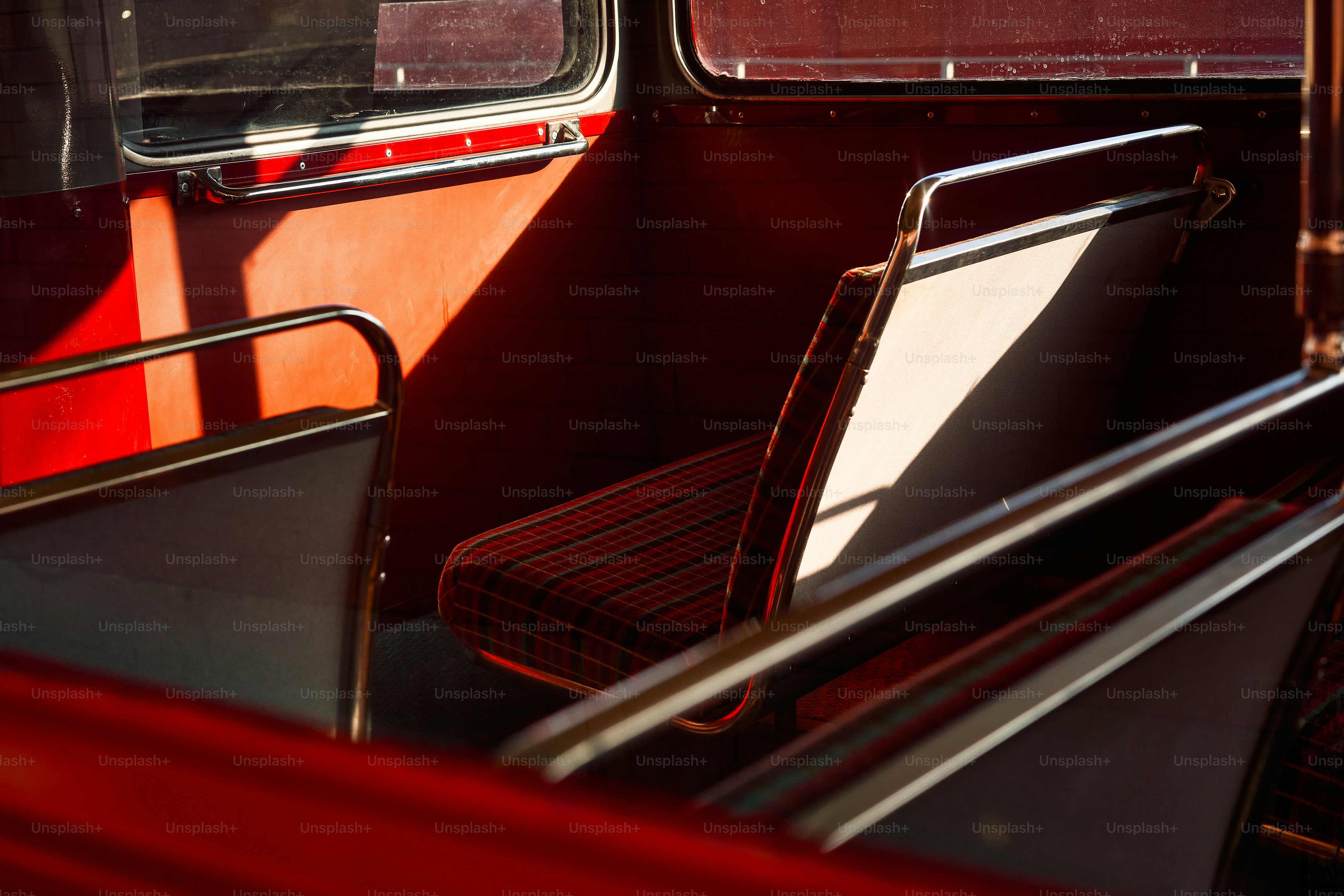 A red and black bus with two seats and a window photo – Brench press ...