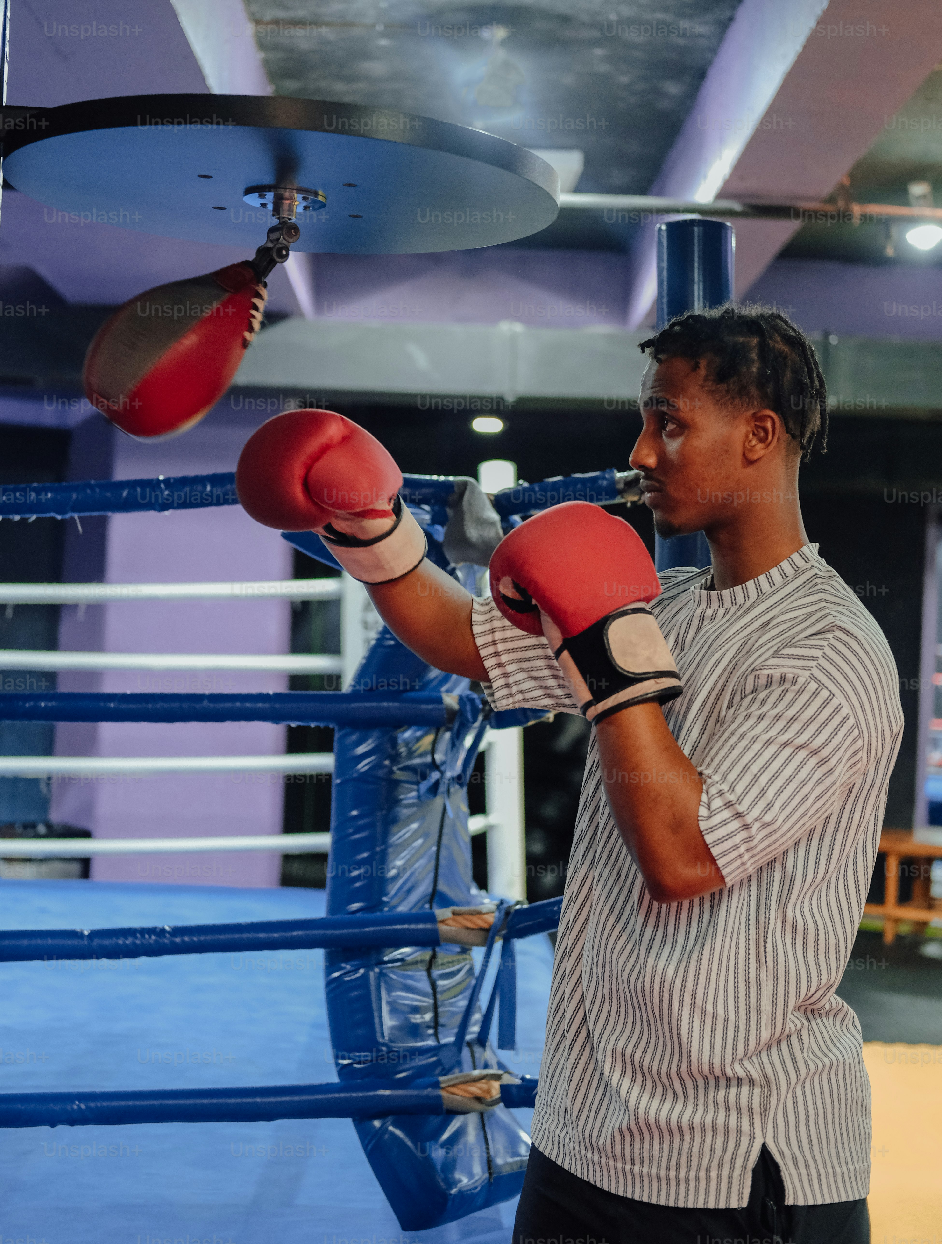 A man standing in a boxing ring wearing red boxing gloves photo ...