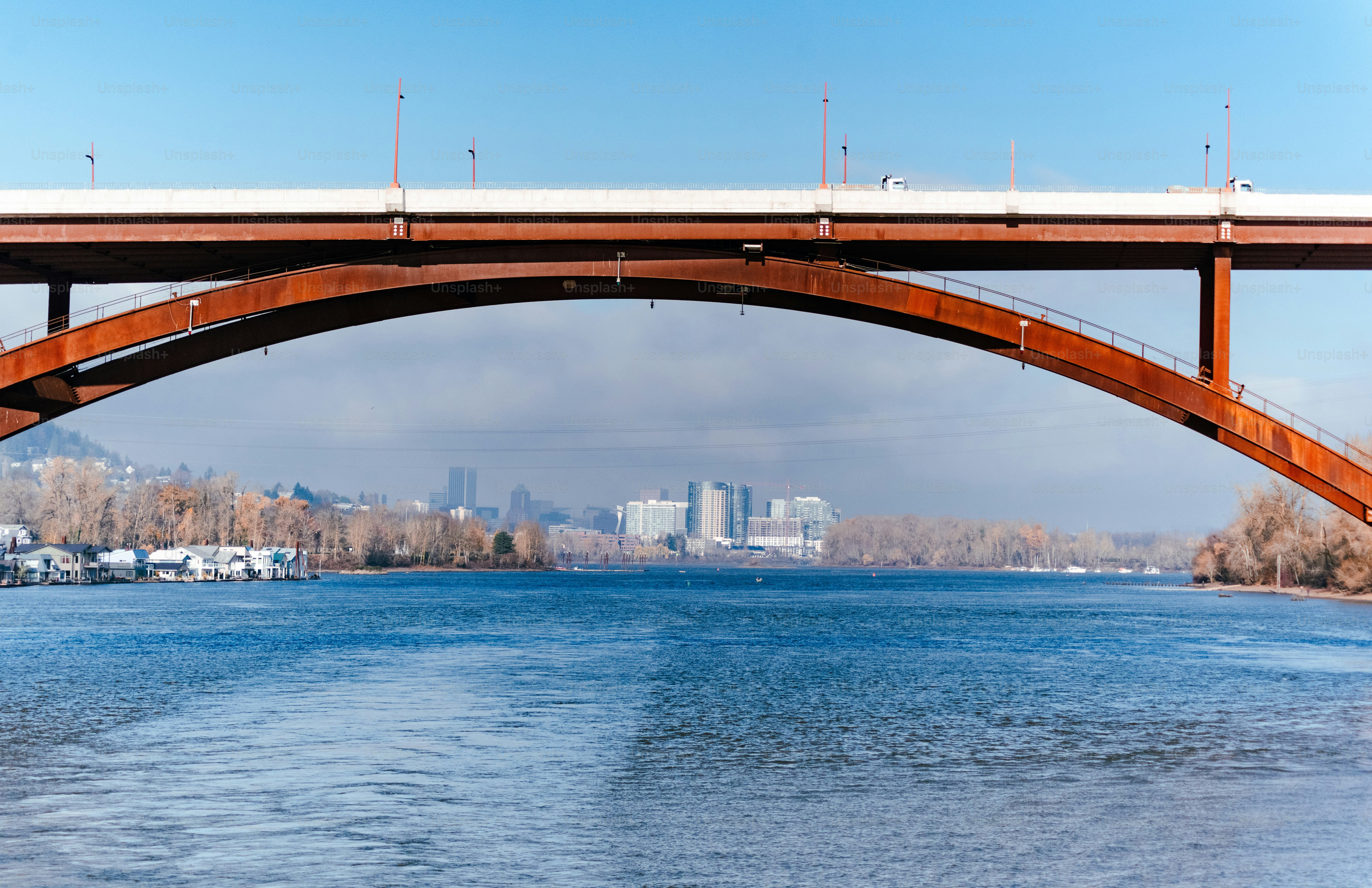 A view of a city with a bridge over a river photo – Bridges Image on ...