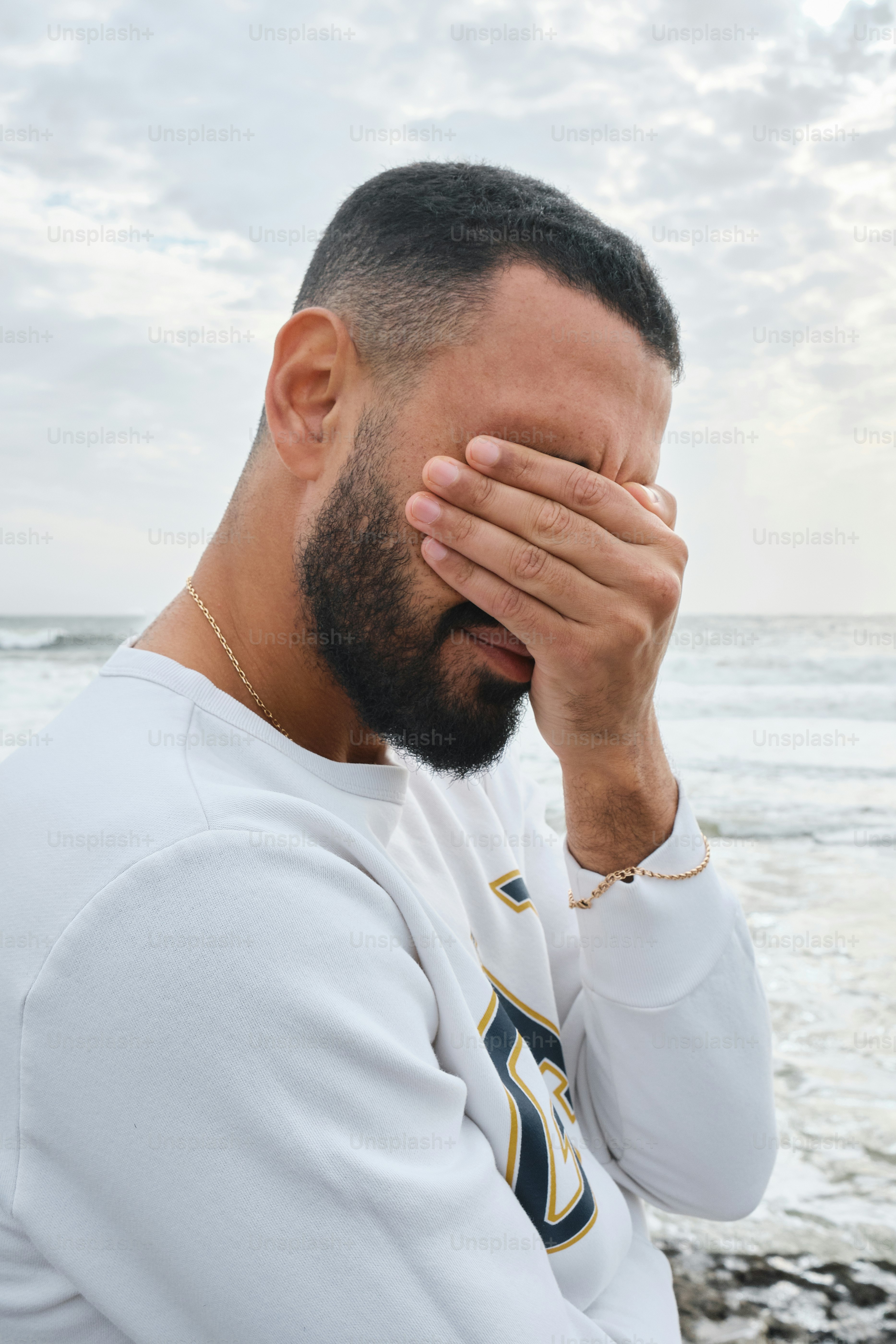 A man covers his face with his hands photo – Fast fashion Image on Unsplash