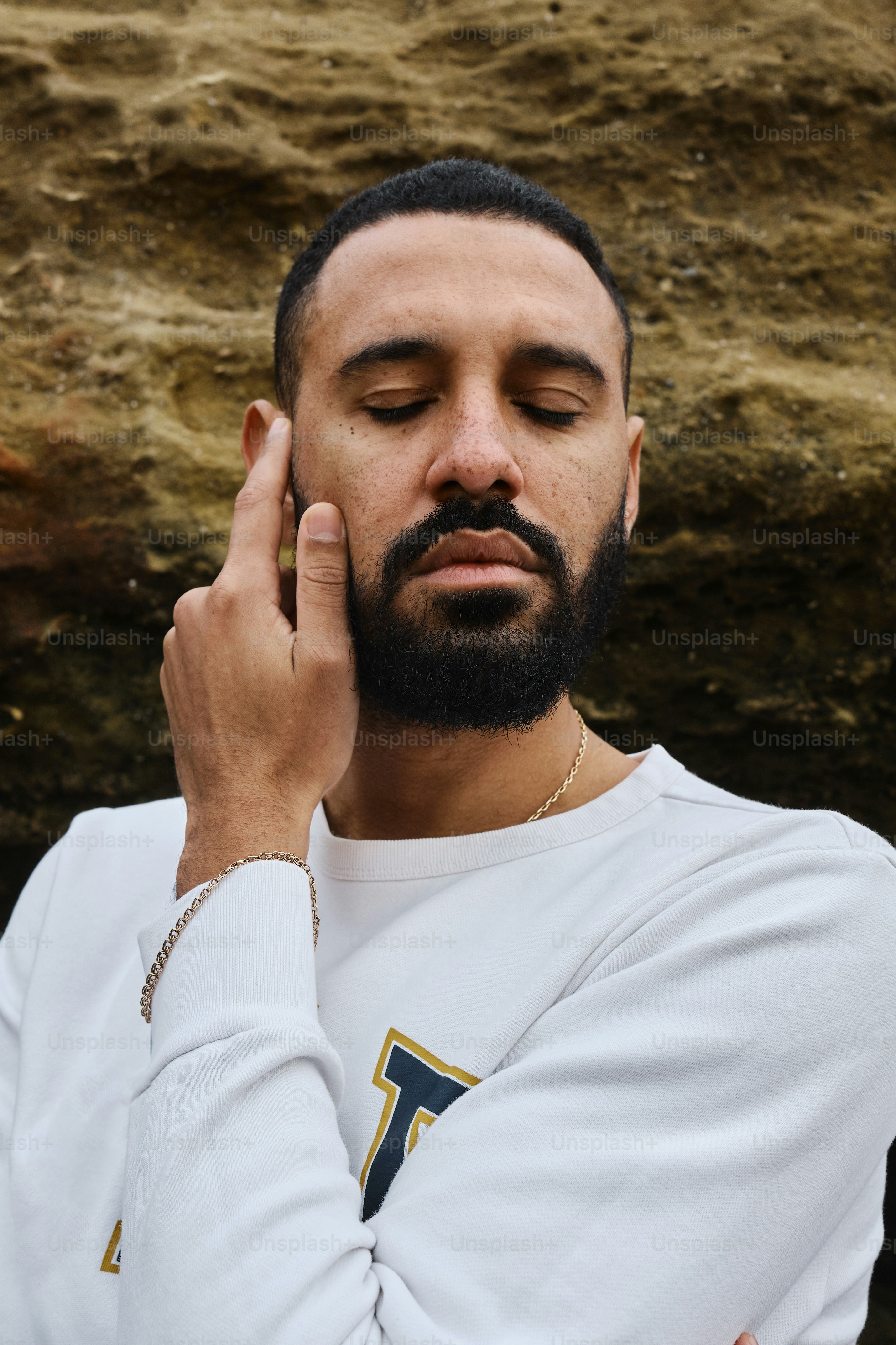 A man with a beard holding his hand to his ear photo – Fast fashion ...