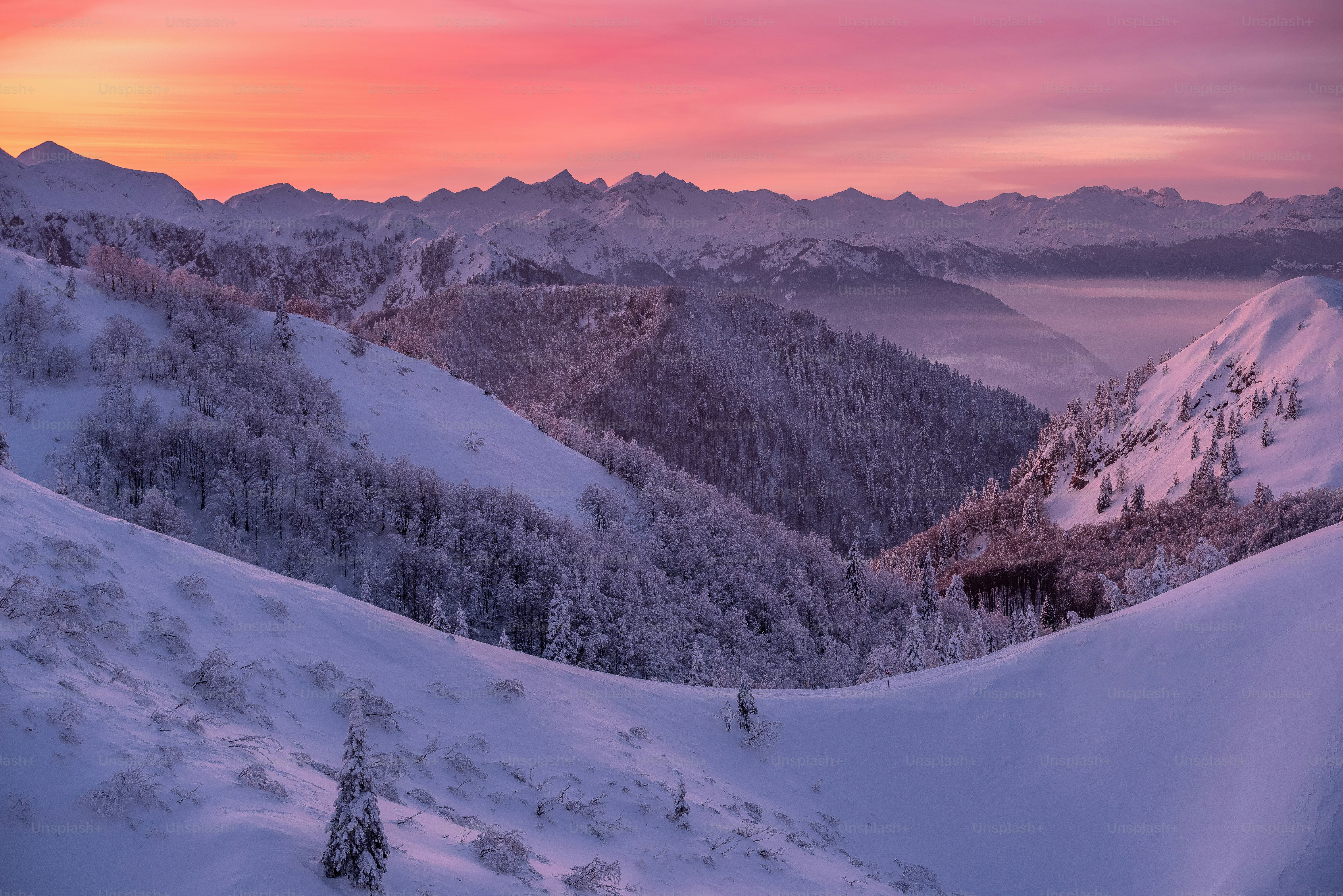 A sunset view of a snowy mountain range photo – Sunset Image on Unsplash