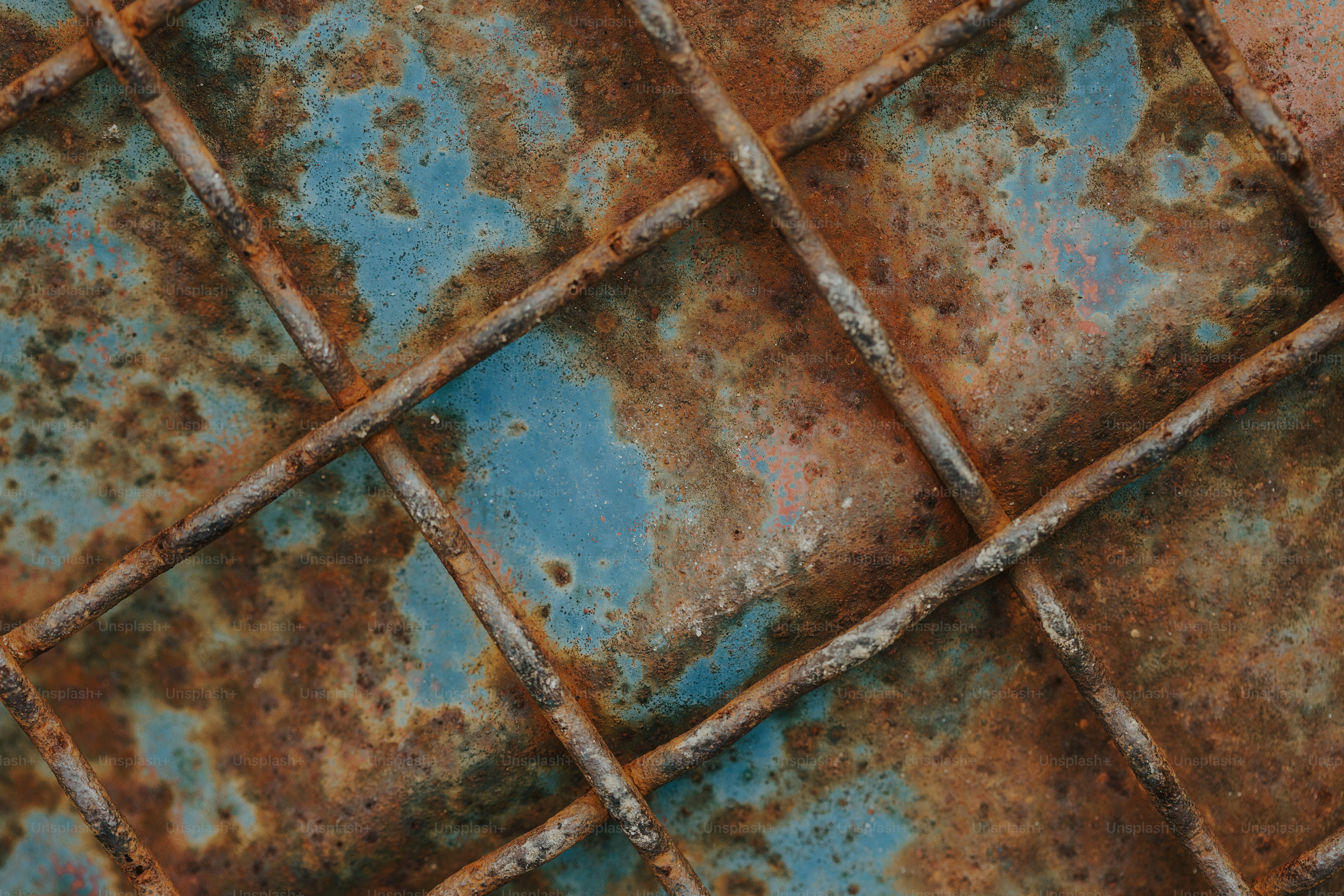 A rusted metal surface with blue and brown squares photo – Texture ...
