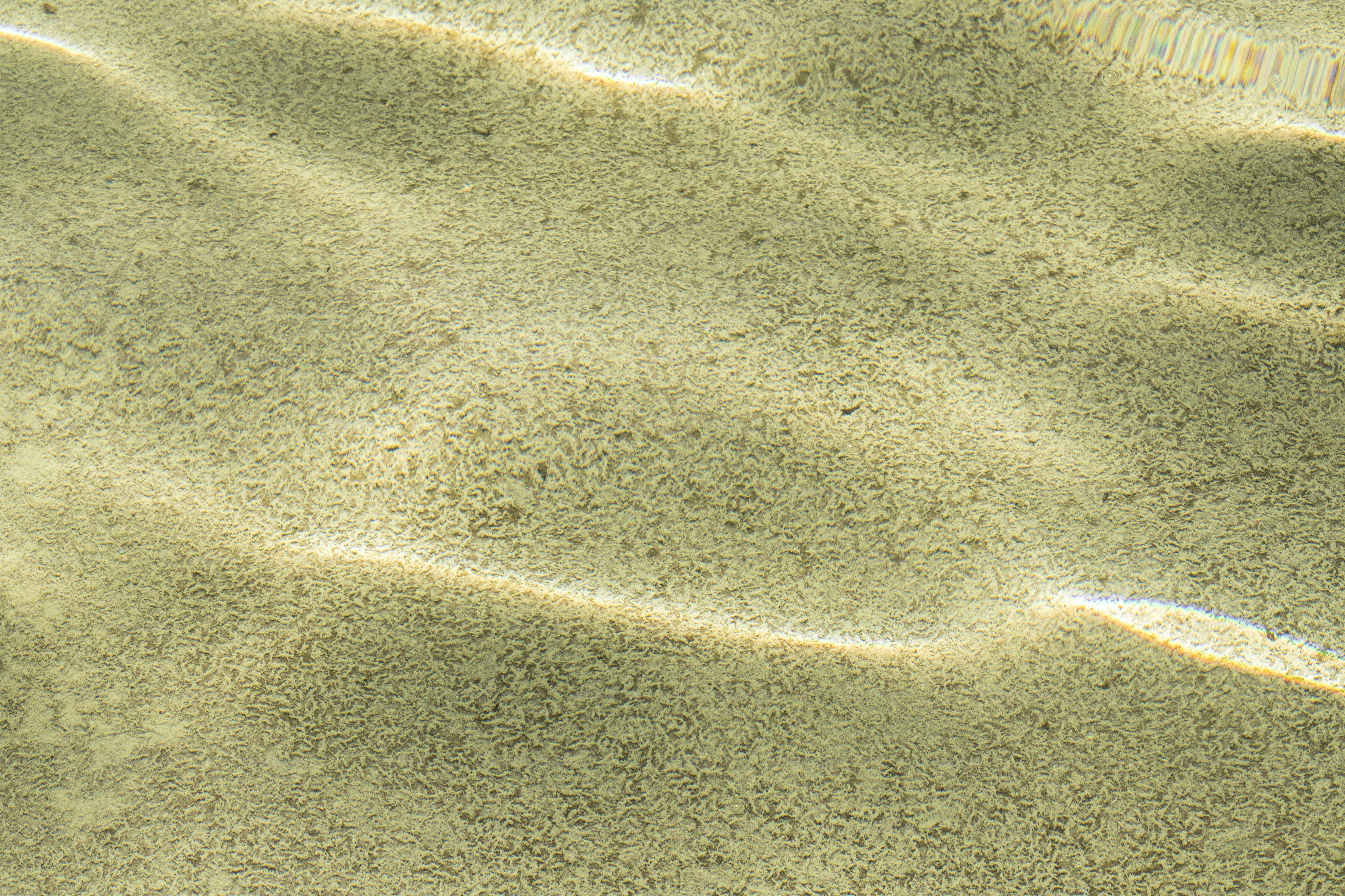 A sandy beach with a small amount of sand photo – Texture Image on Unsplash