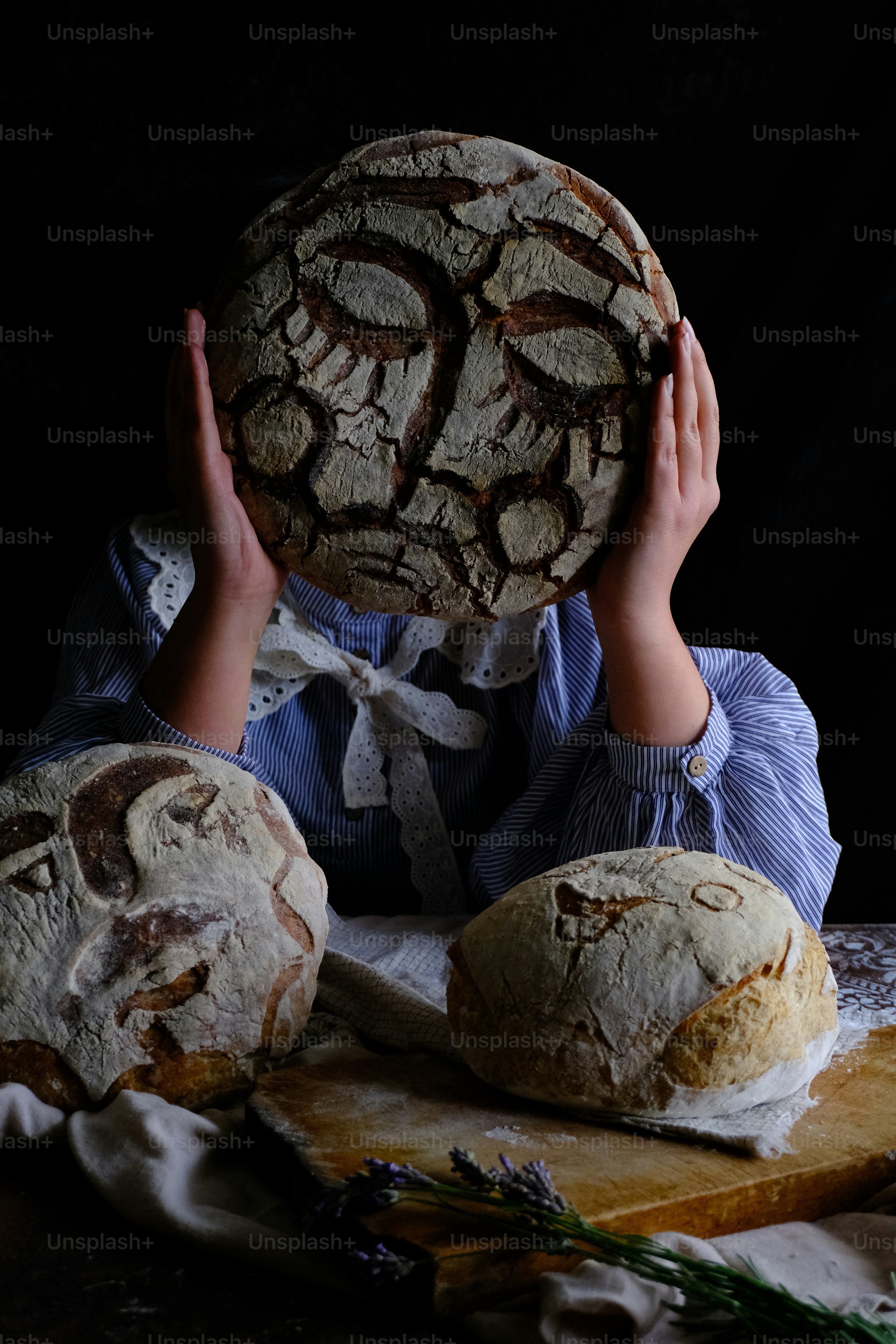 A person holding a loaf of bread over their face photo – Lonely Image ...