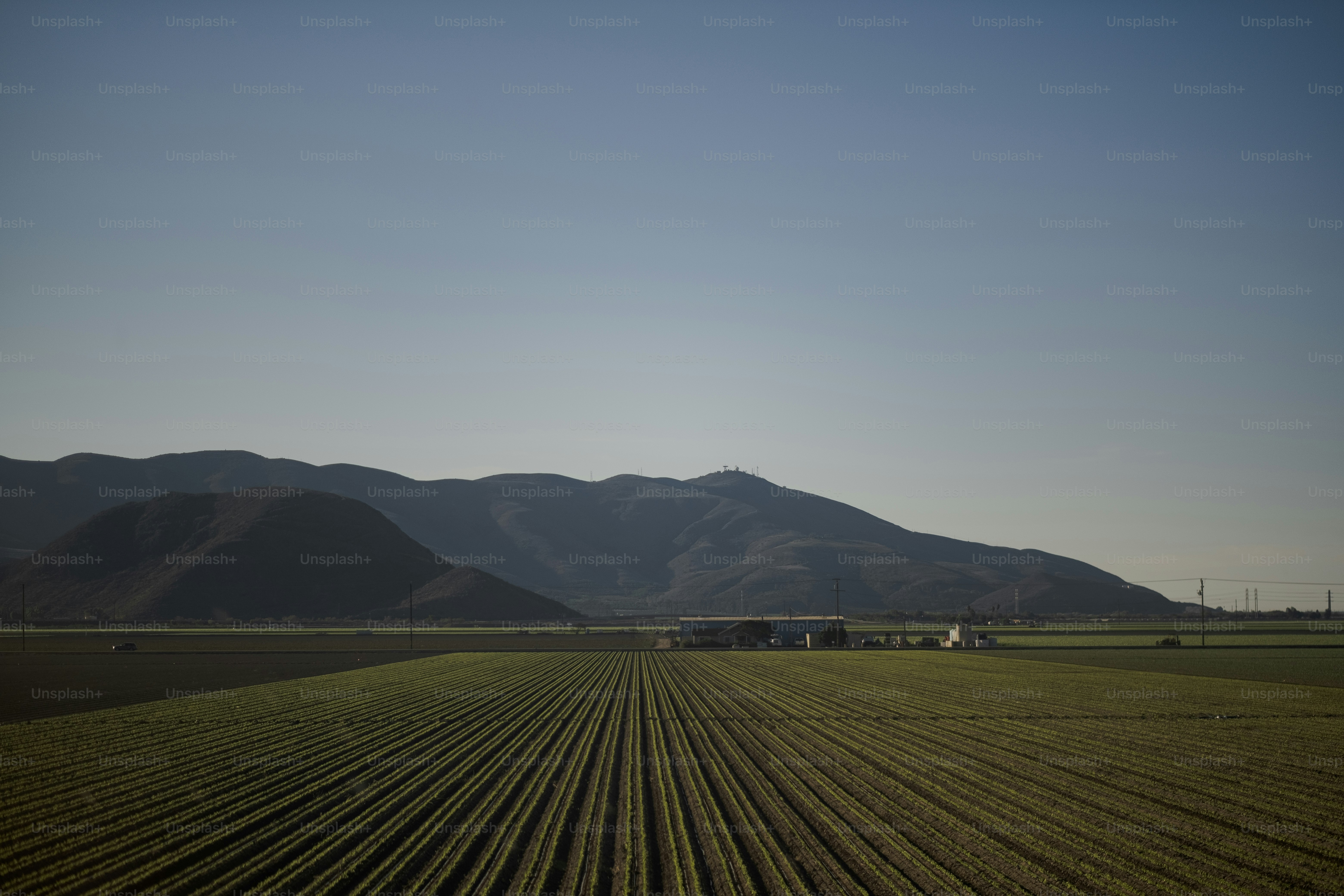 A farm field with mountains in the background photo – Farm landscape ...