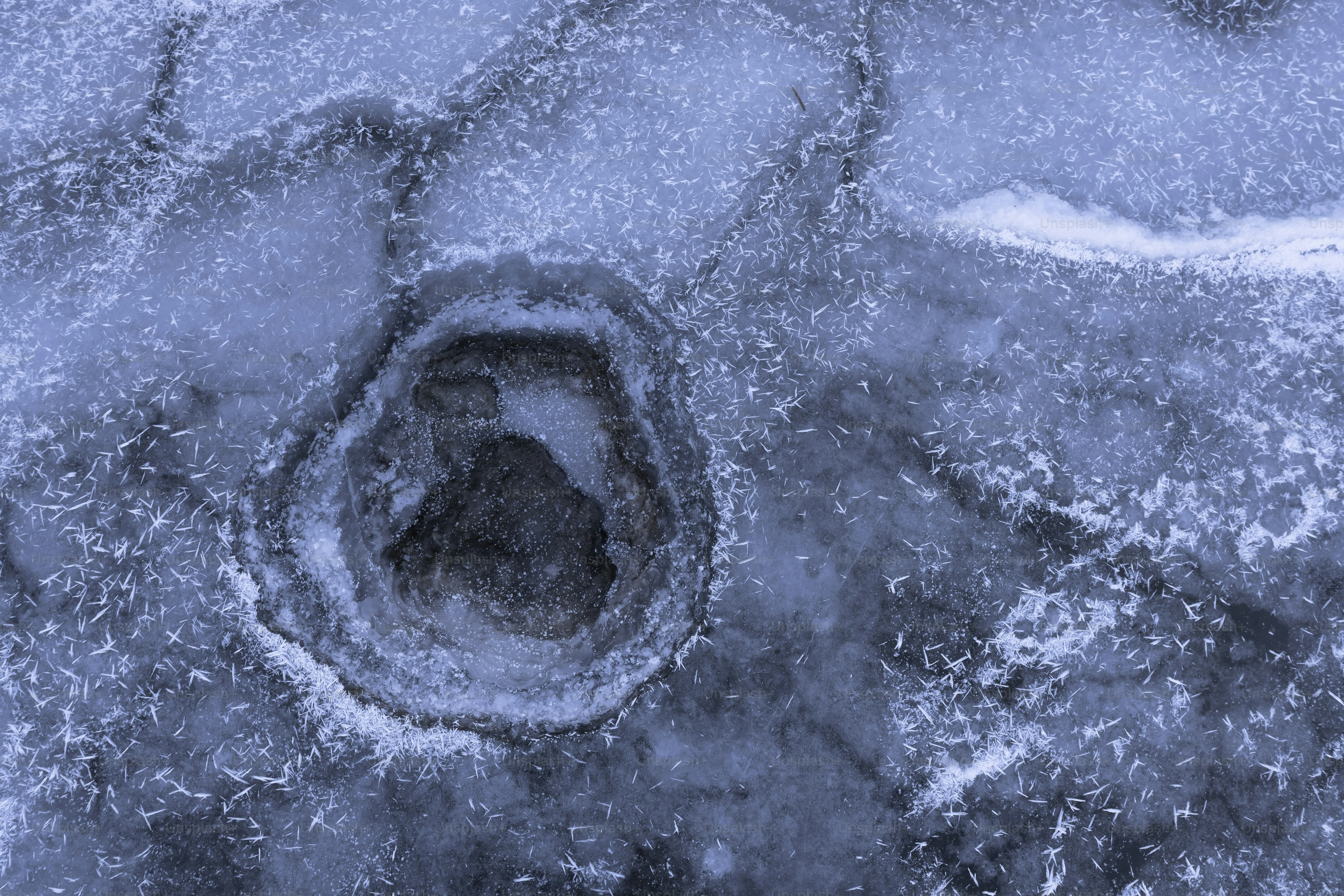 A small hole in the ice that looks like a hole in the ground photo ...