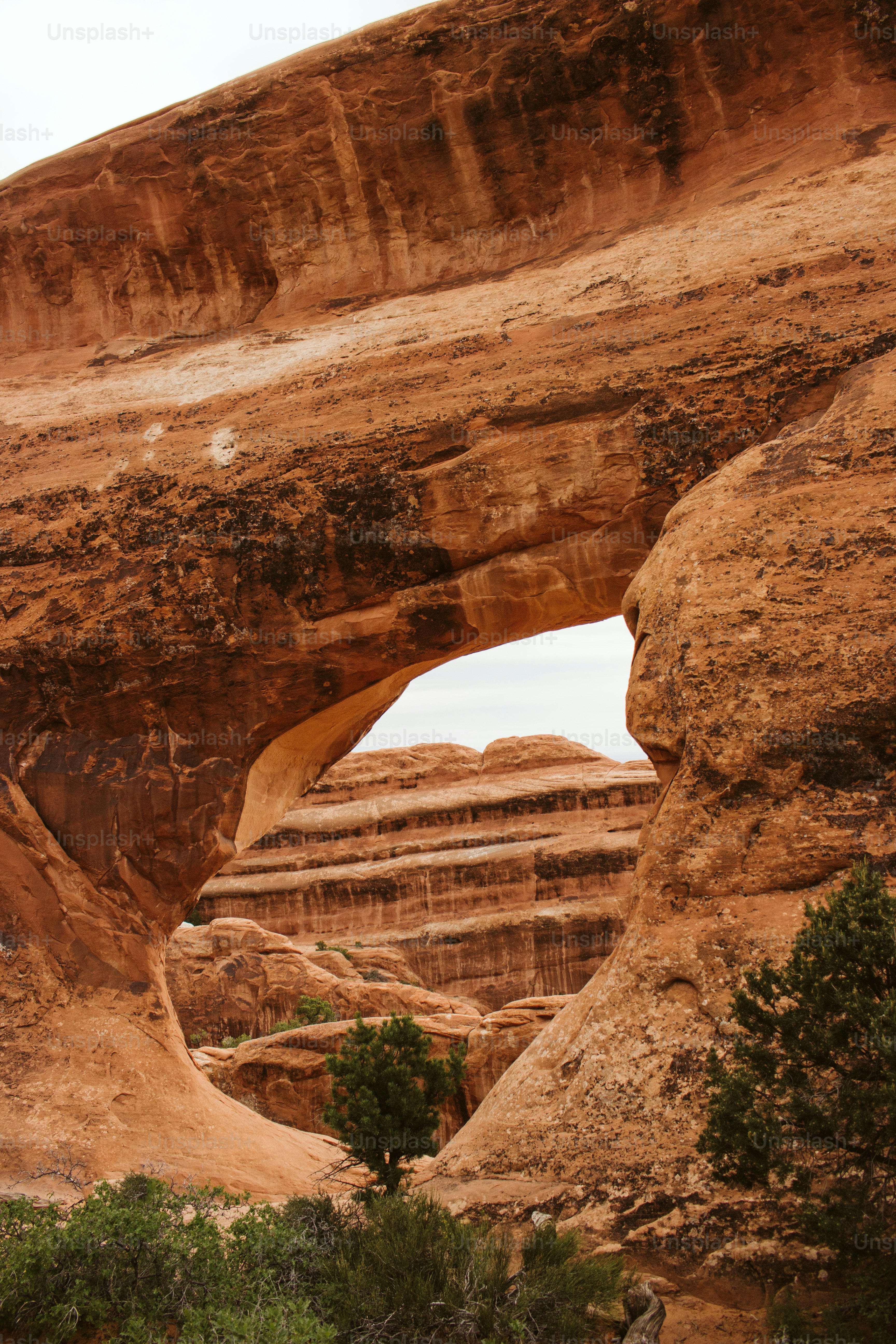 A large rock formation with a bridge in the middle of it photo ...