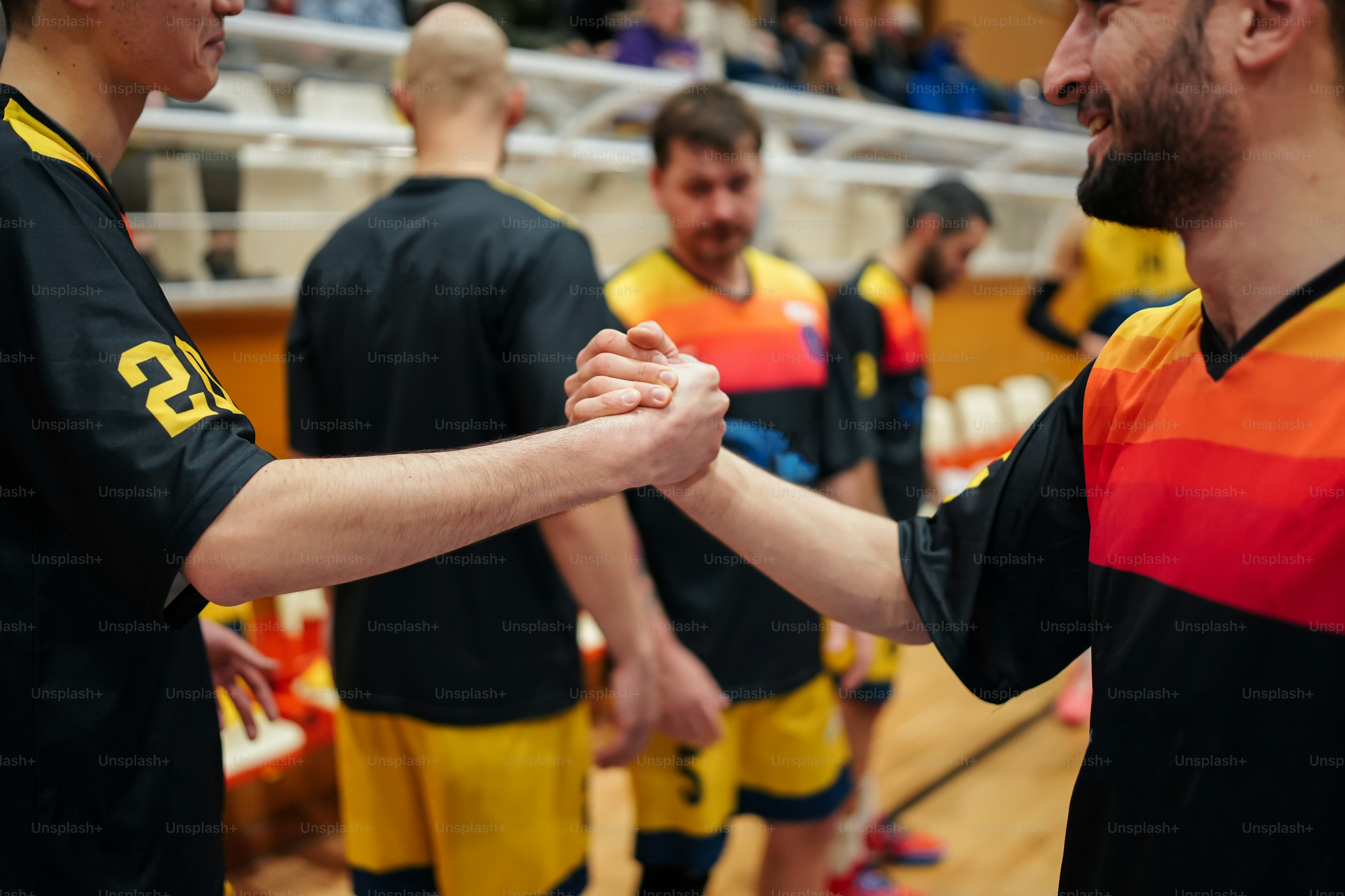 A group of men standing next to each other on a basketball court photo ...