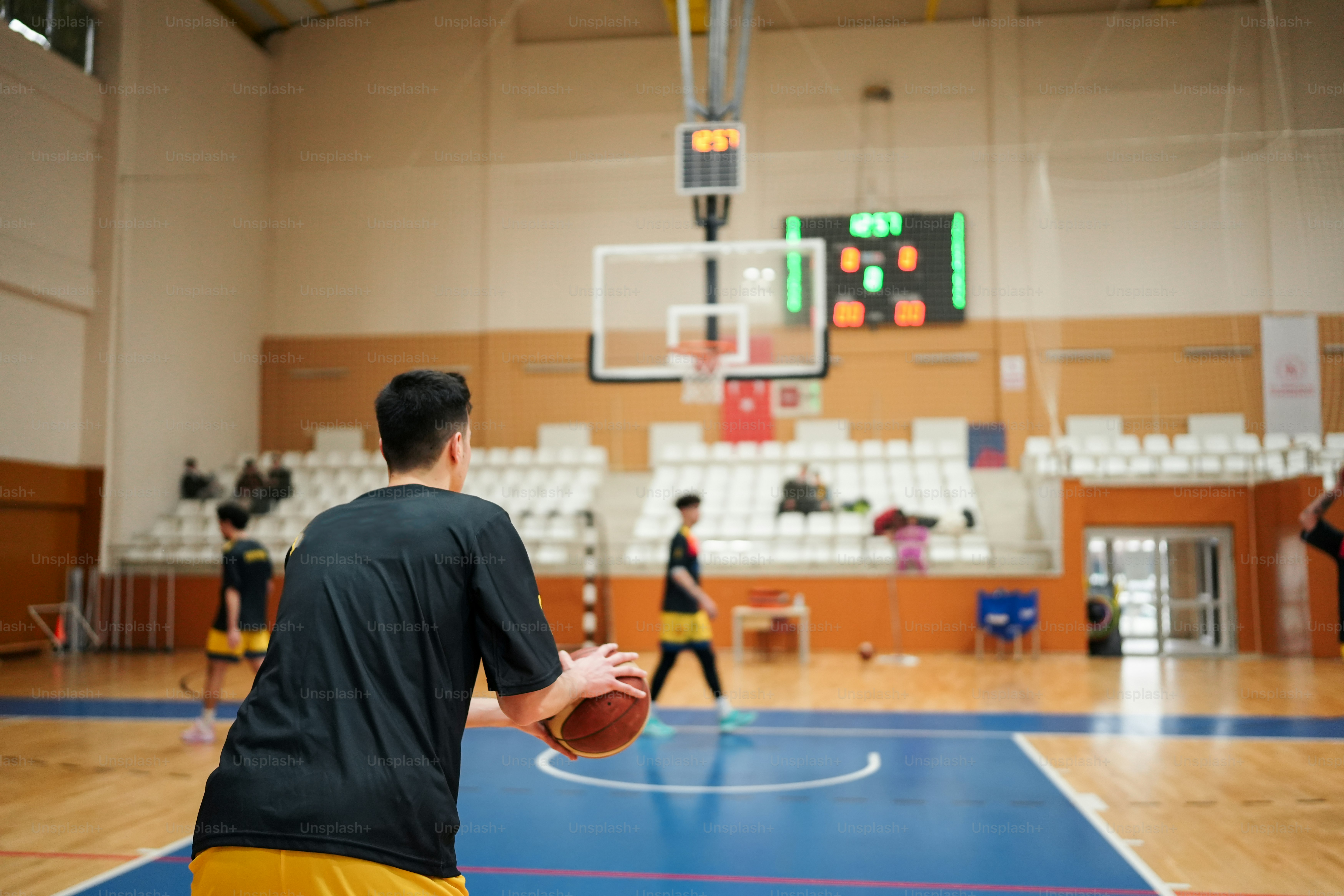 A group of young men playing a game of basketball photo – Basketball ...