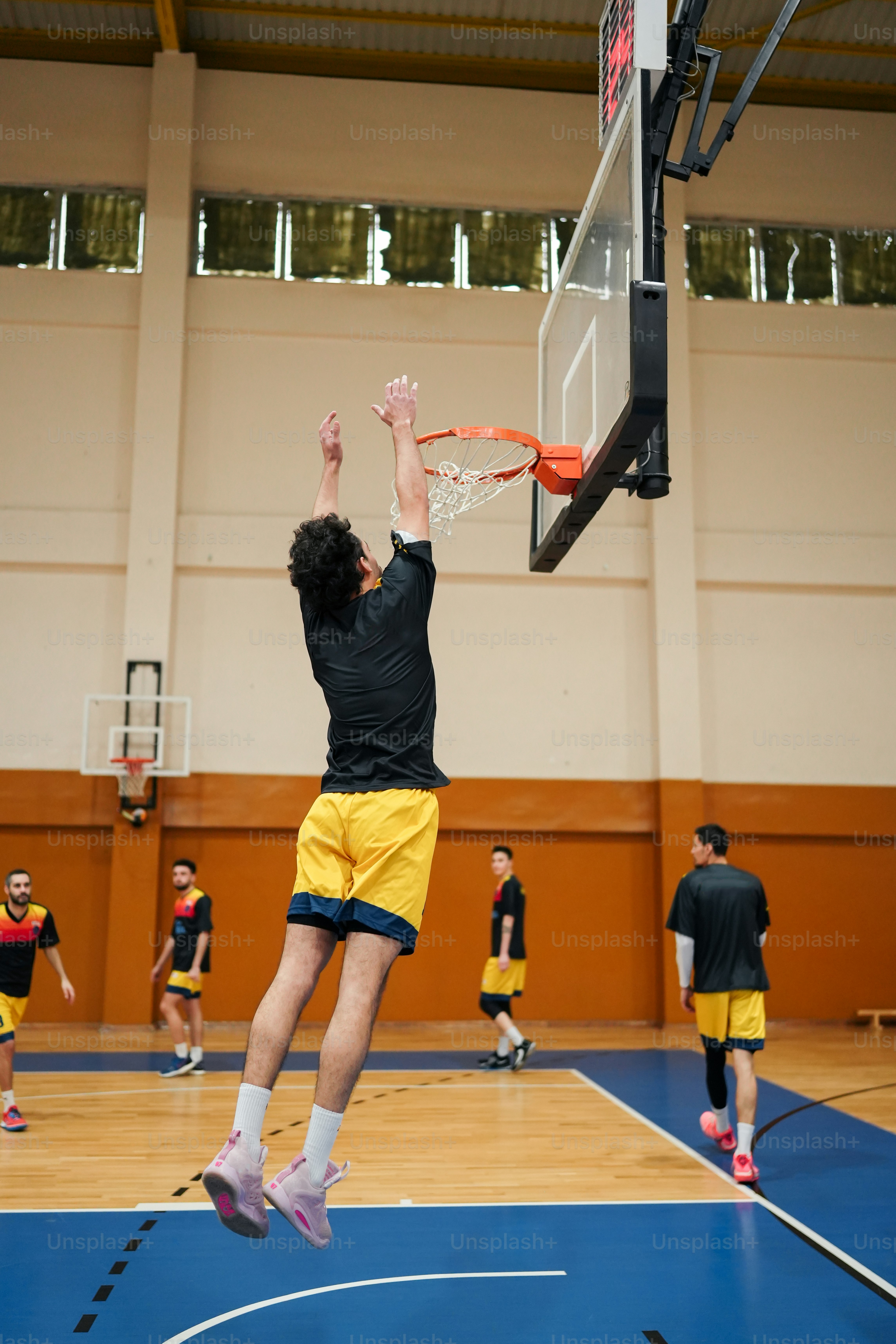 A man jumping up into the air to dunk a basketball photo – Basketball ...