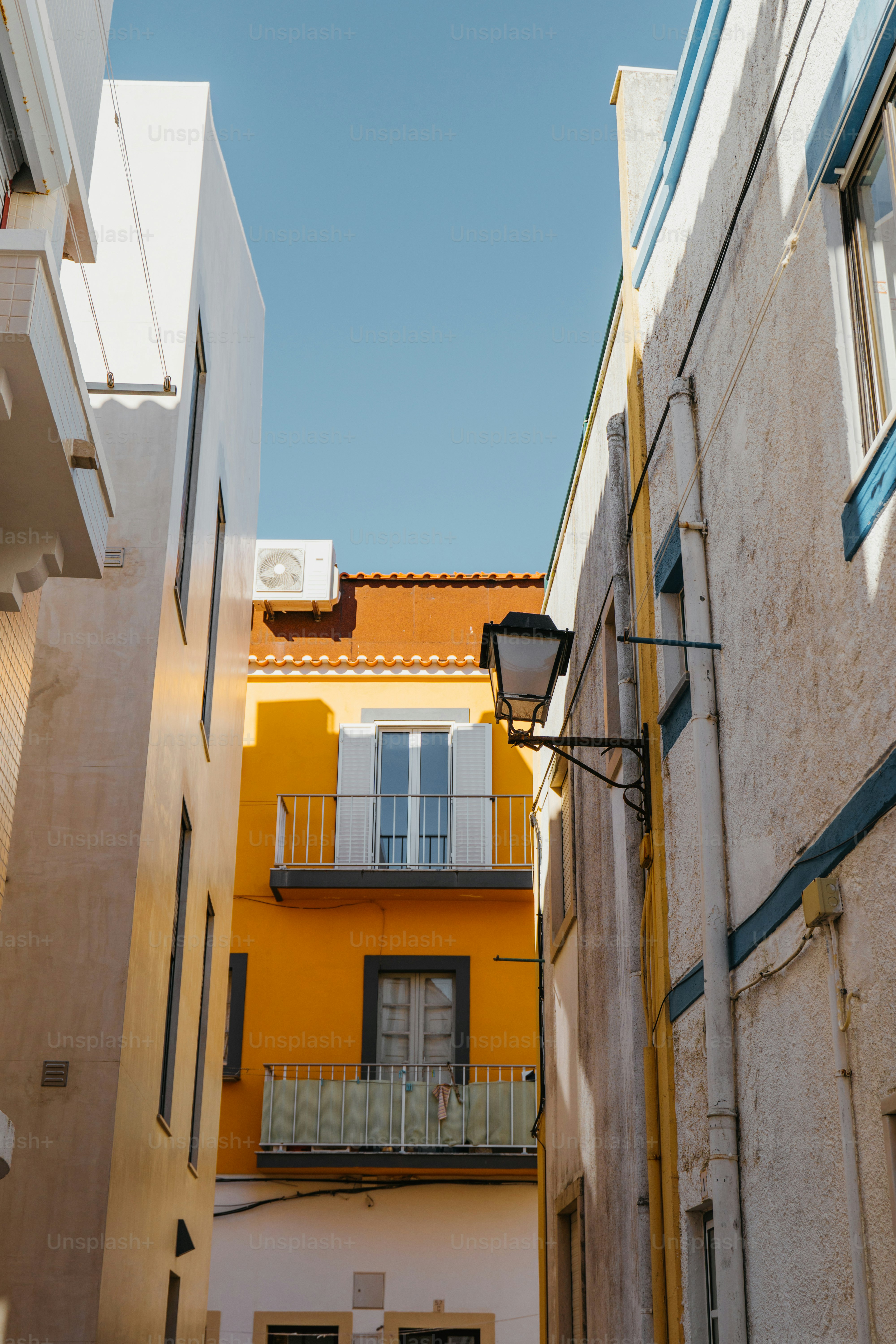 A narrow alley way between two buildings with balconies photo ...