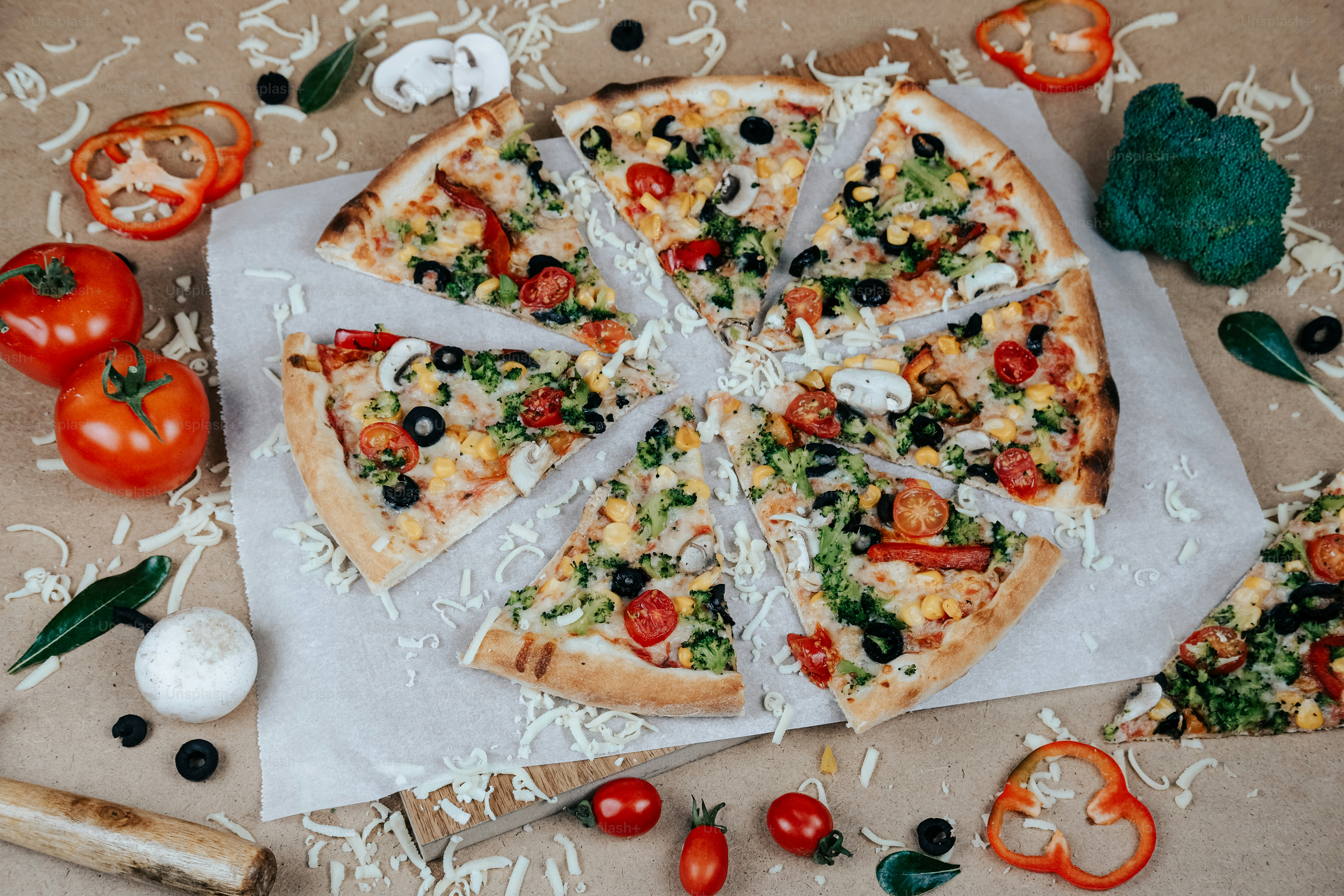A pizza sitting on top of a table covered in toppings photo ...
