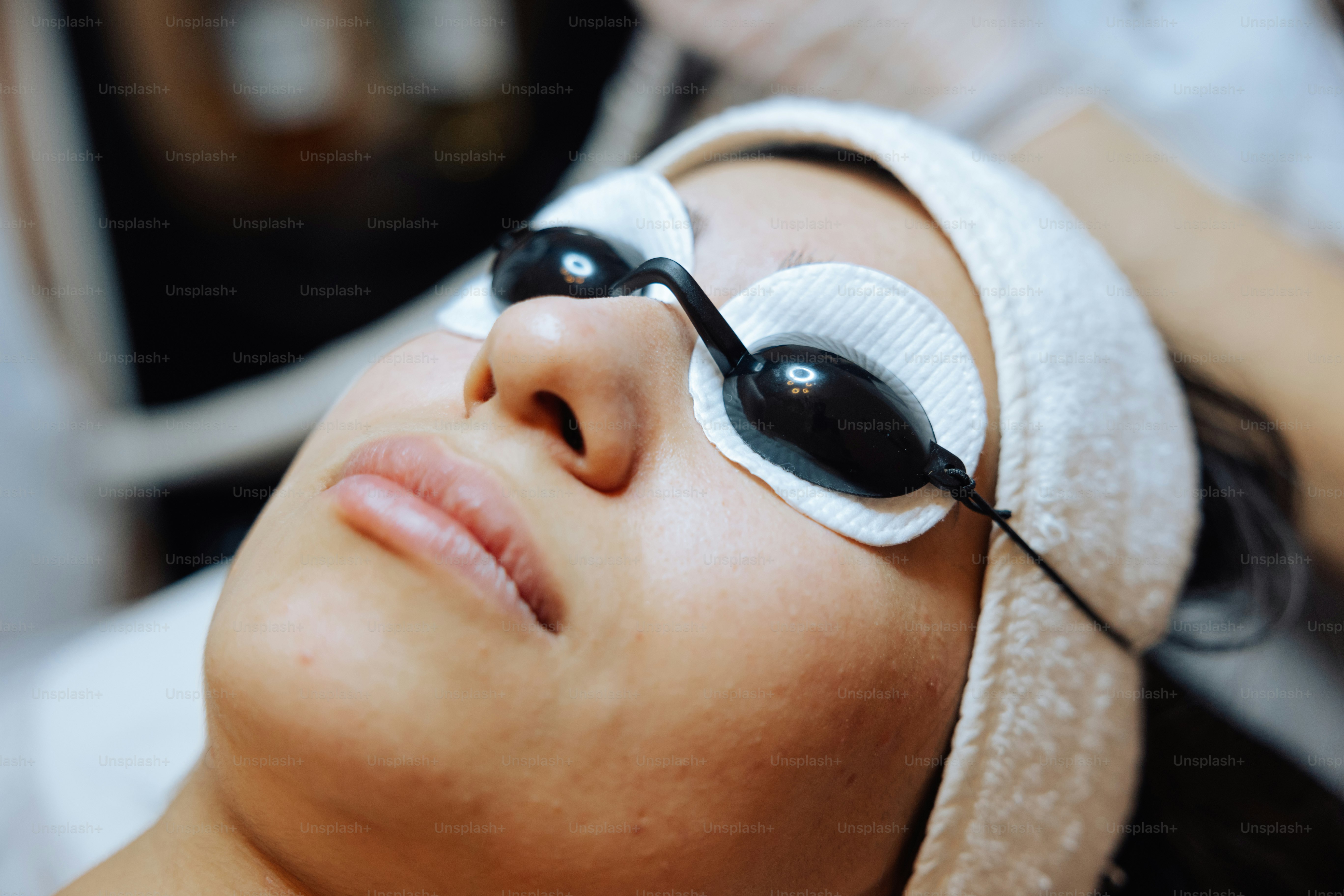 Una mujer se está poniendo una máscara facial en la cara foto – Imagen ...