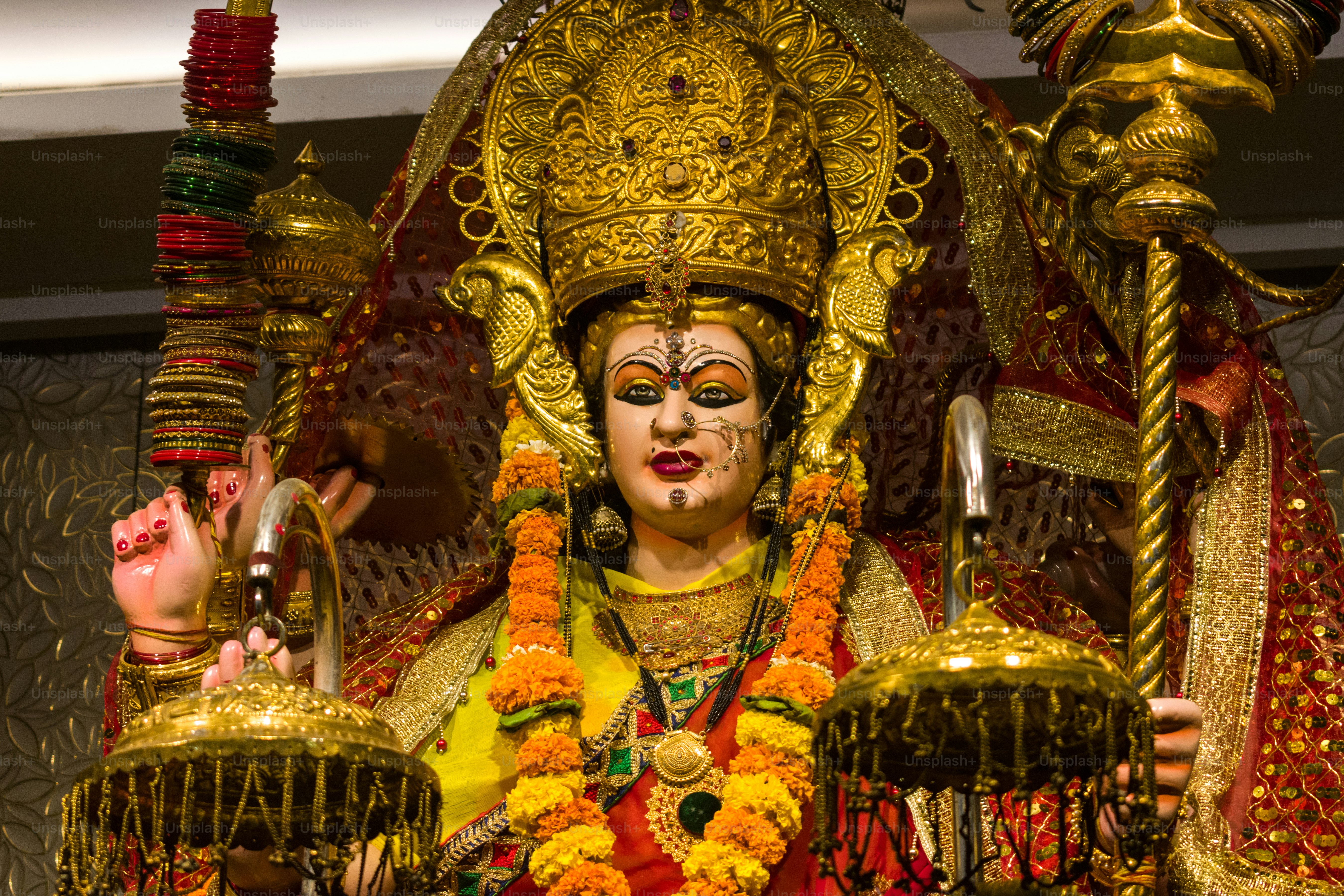 A close up of a statue of a person holding two bells photo ...