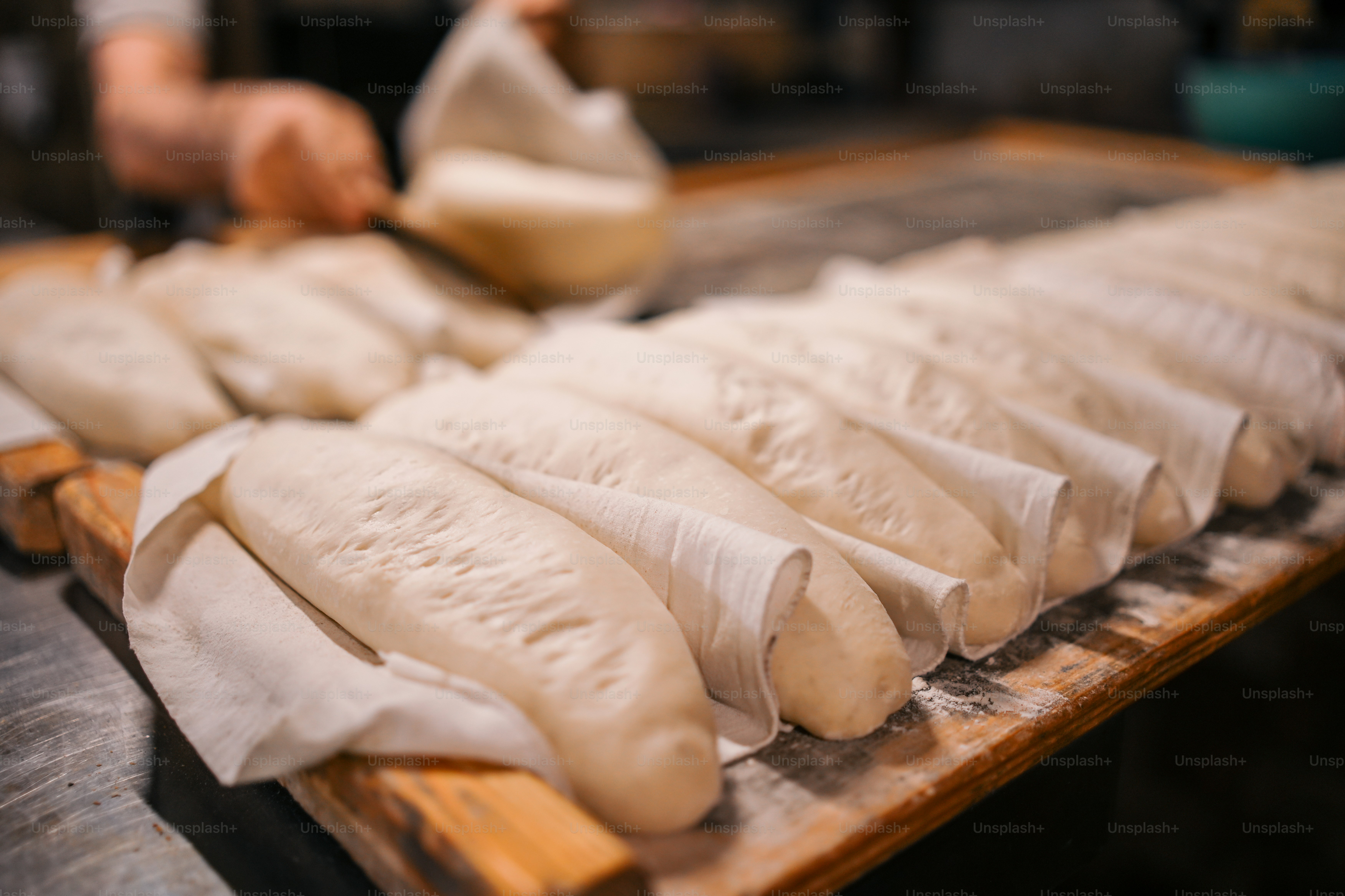 A wooden table topped with lots of uncooked bread photo – Professional ...