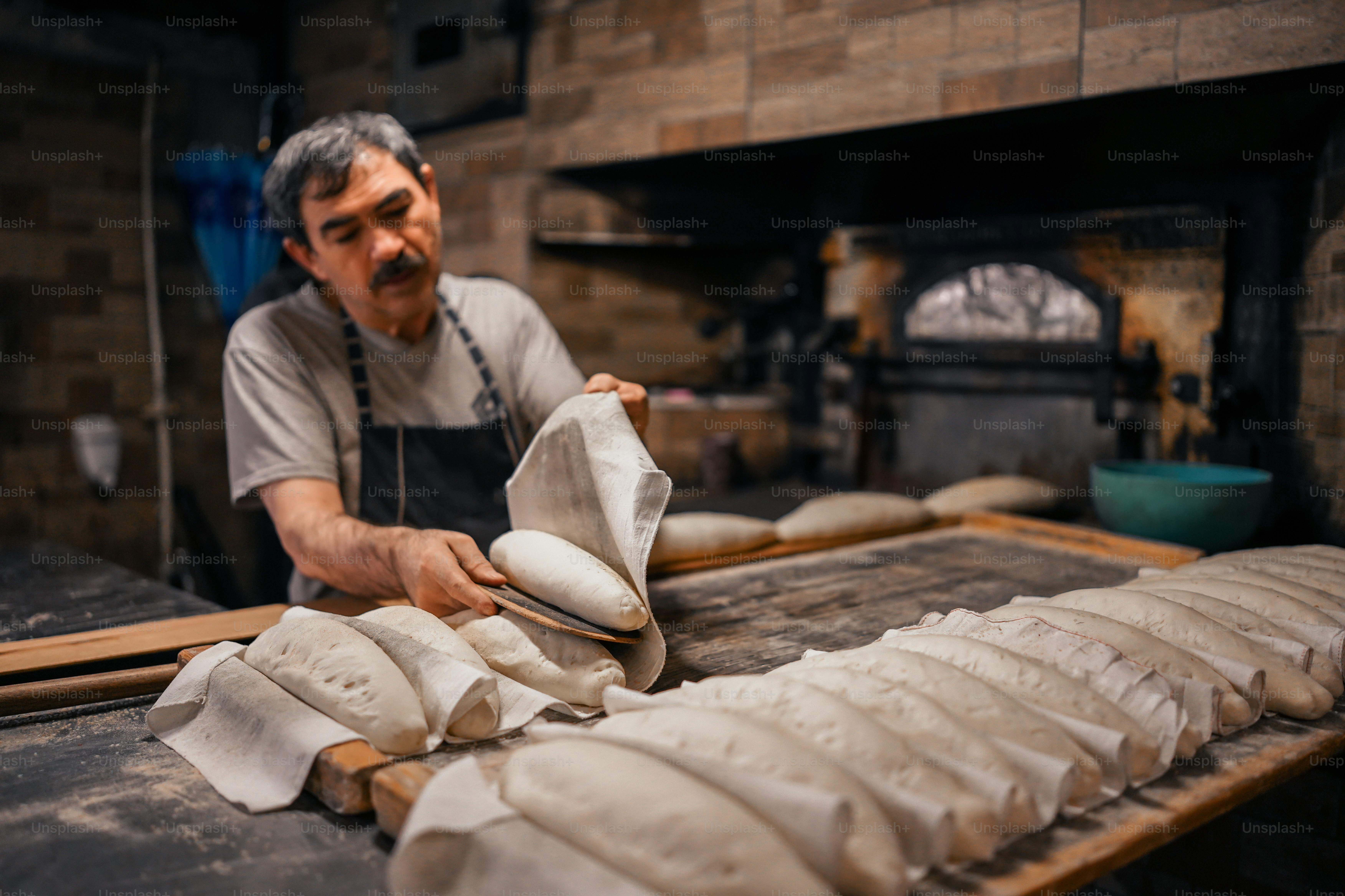Two men working in a bakery making bread photo – Baking bread Image on ...