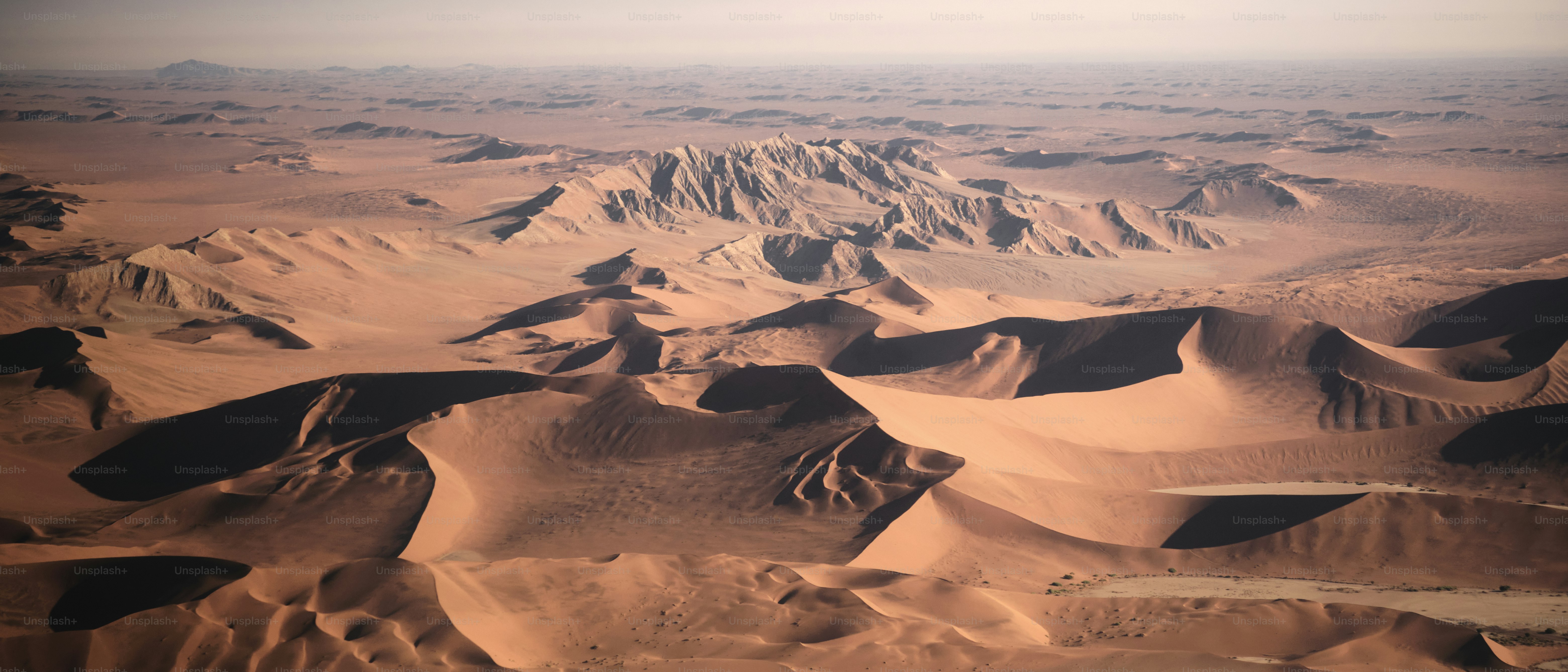 An aerial view of a desert with a lake in the middle of it photo ...