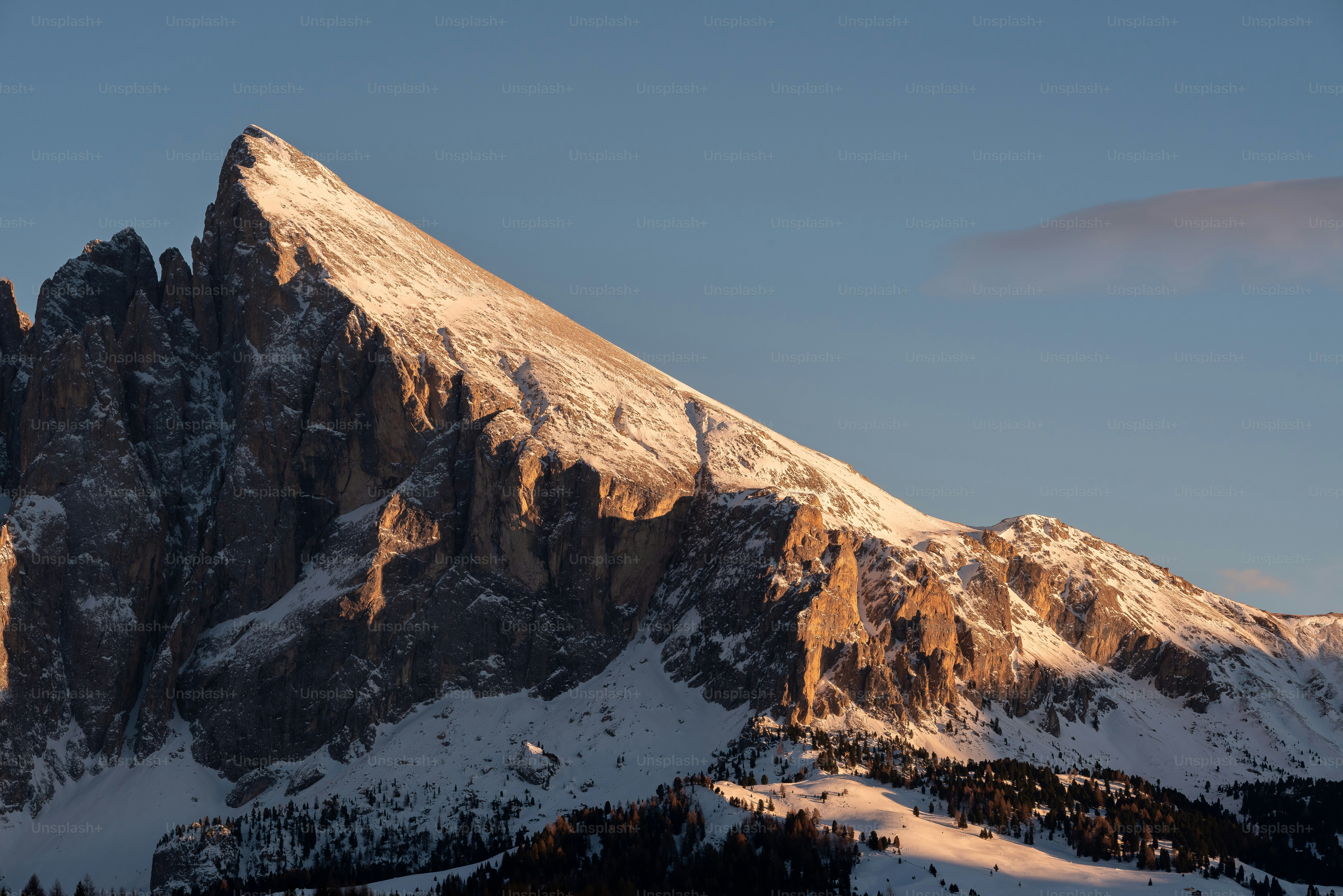 A very tall mountain covered in snow under a blue sky photo – Mountain ...