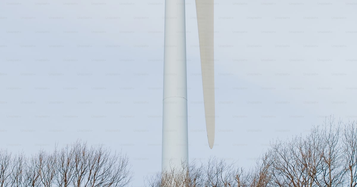 Foto Zum Thema Eine Windkraftanlage Auf Einem Feld Mit Bäumen Im