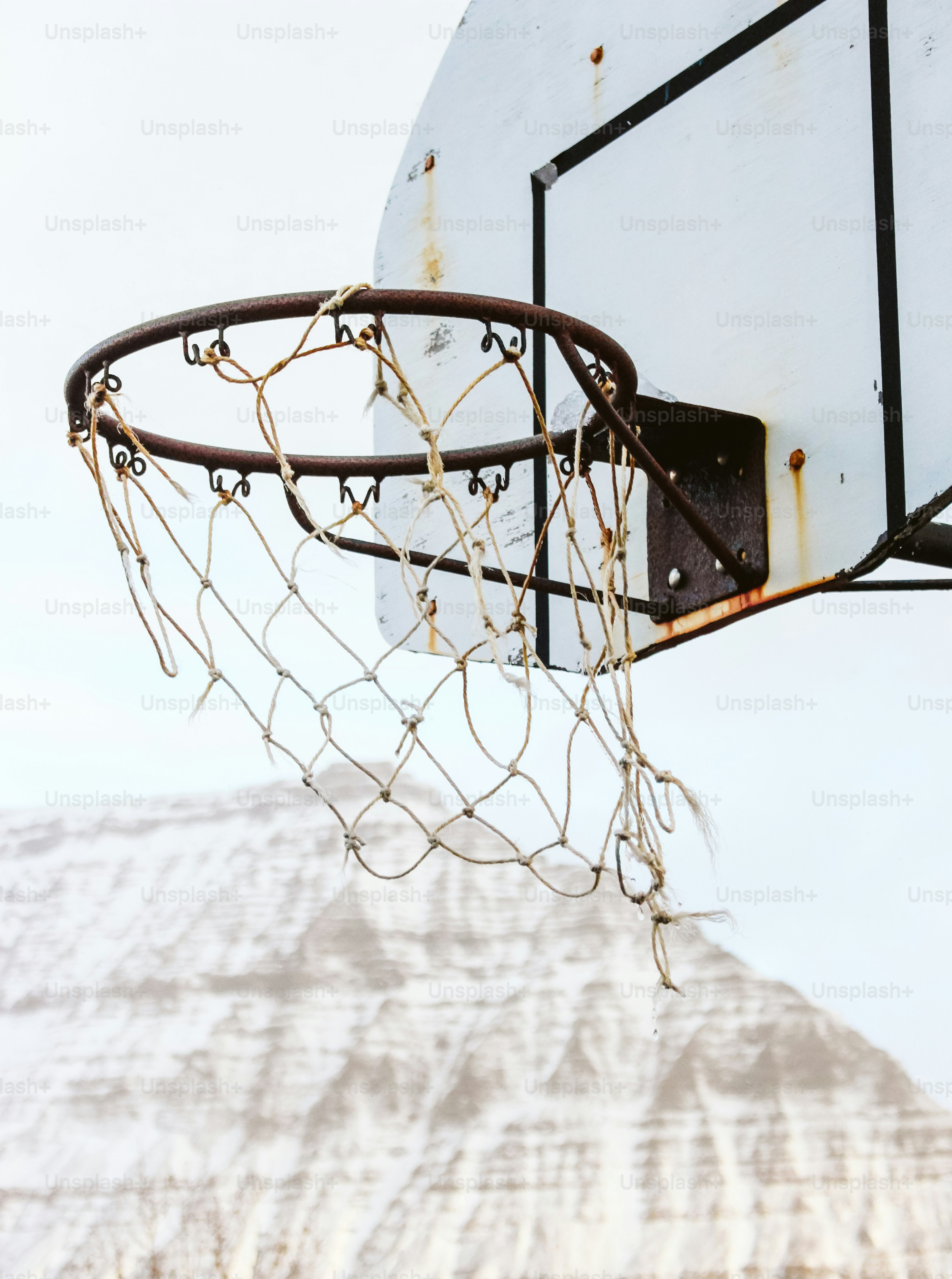 A close up of a basketball hoop with a mountain in the background photo ...