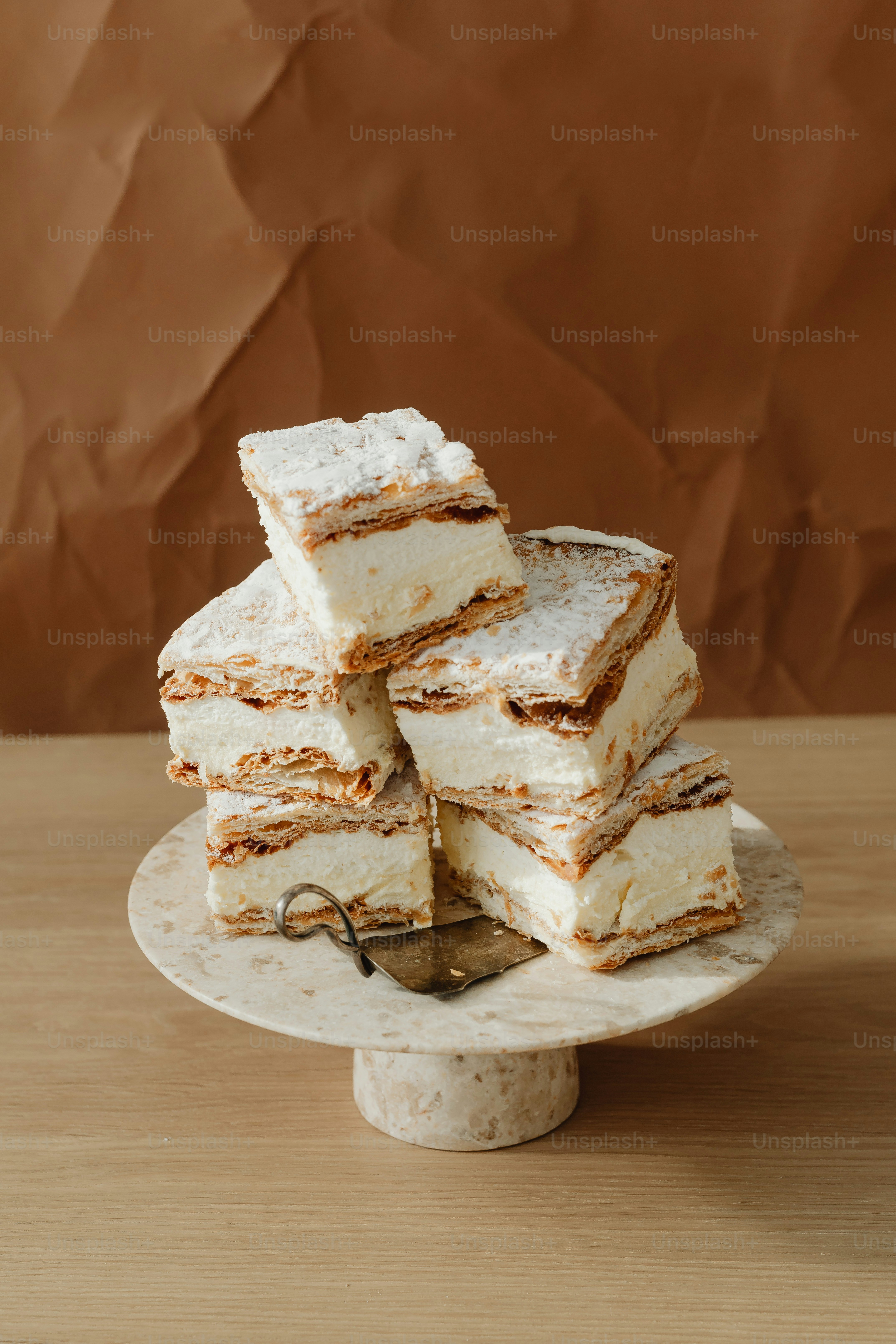 A stack of cake sitting on top of a white plate photo – Food Image on ...