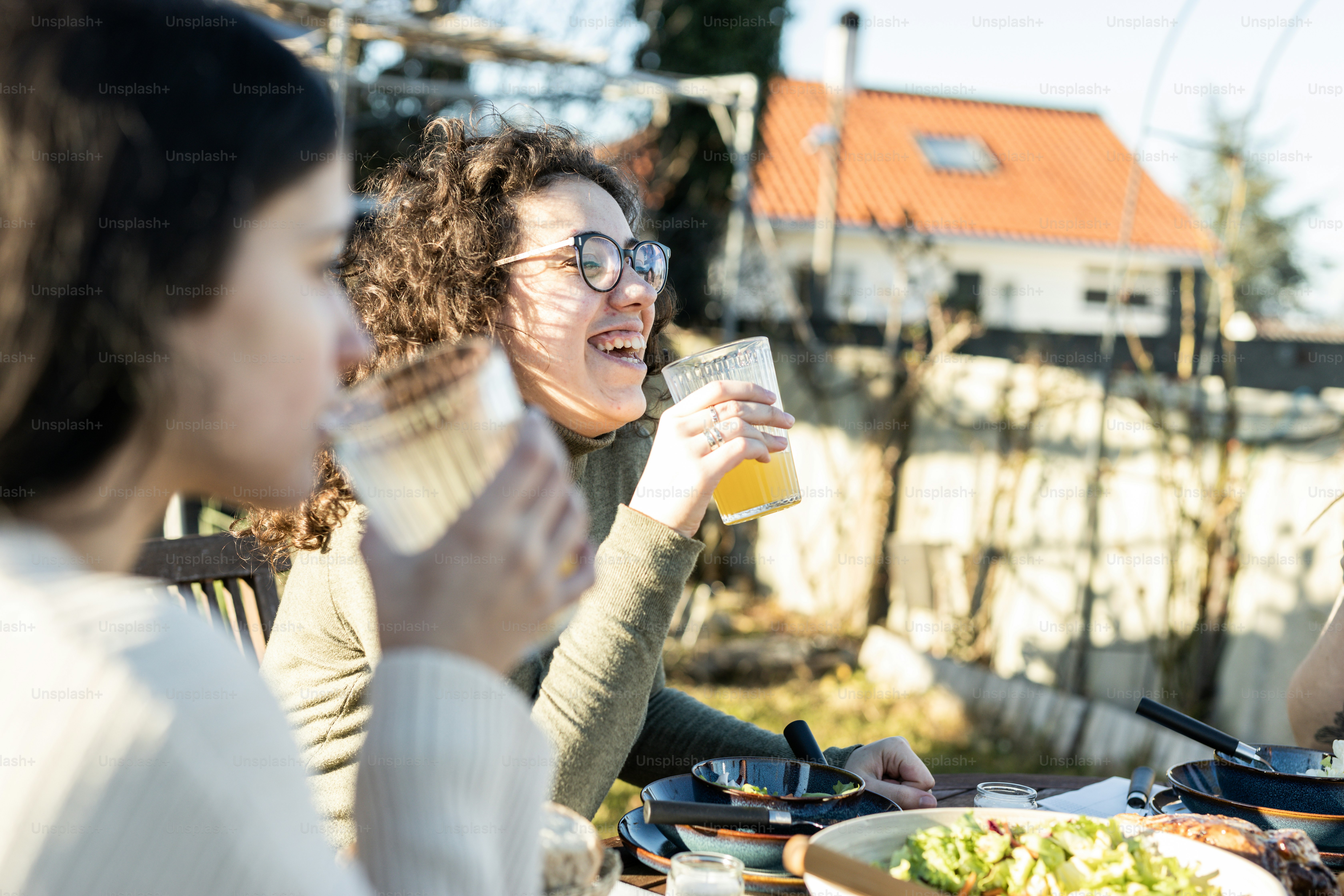 Un groupe de personnes assises autour d’une table en train de manger de ...