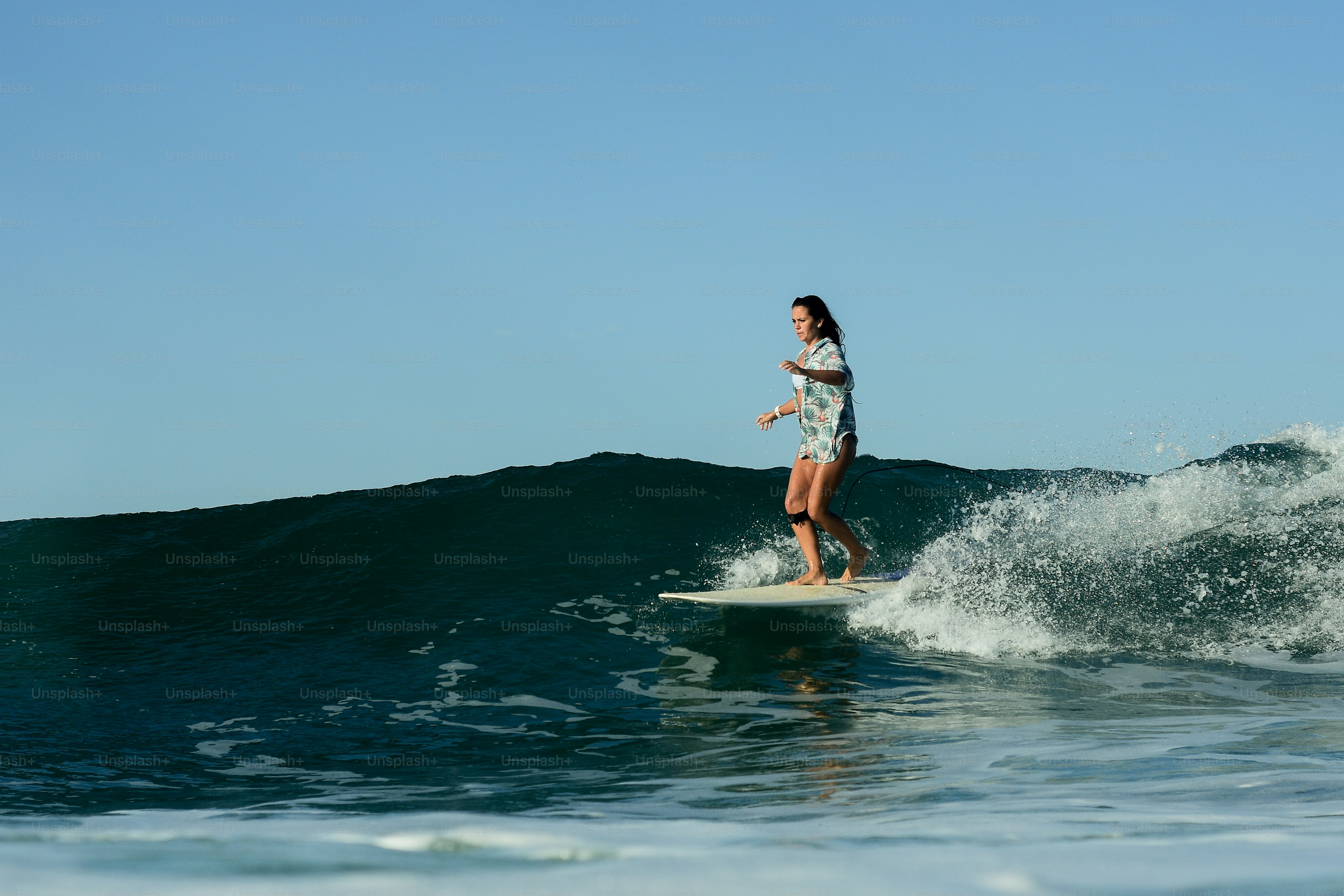 A woman riding a wave on top of a surfboard photo – Surfer girl Image ...