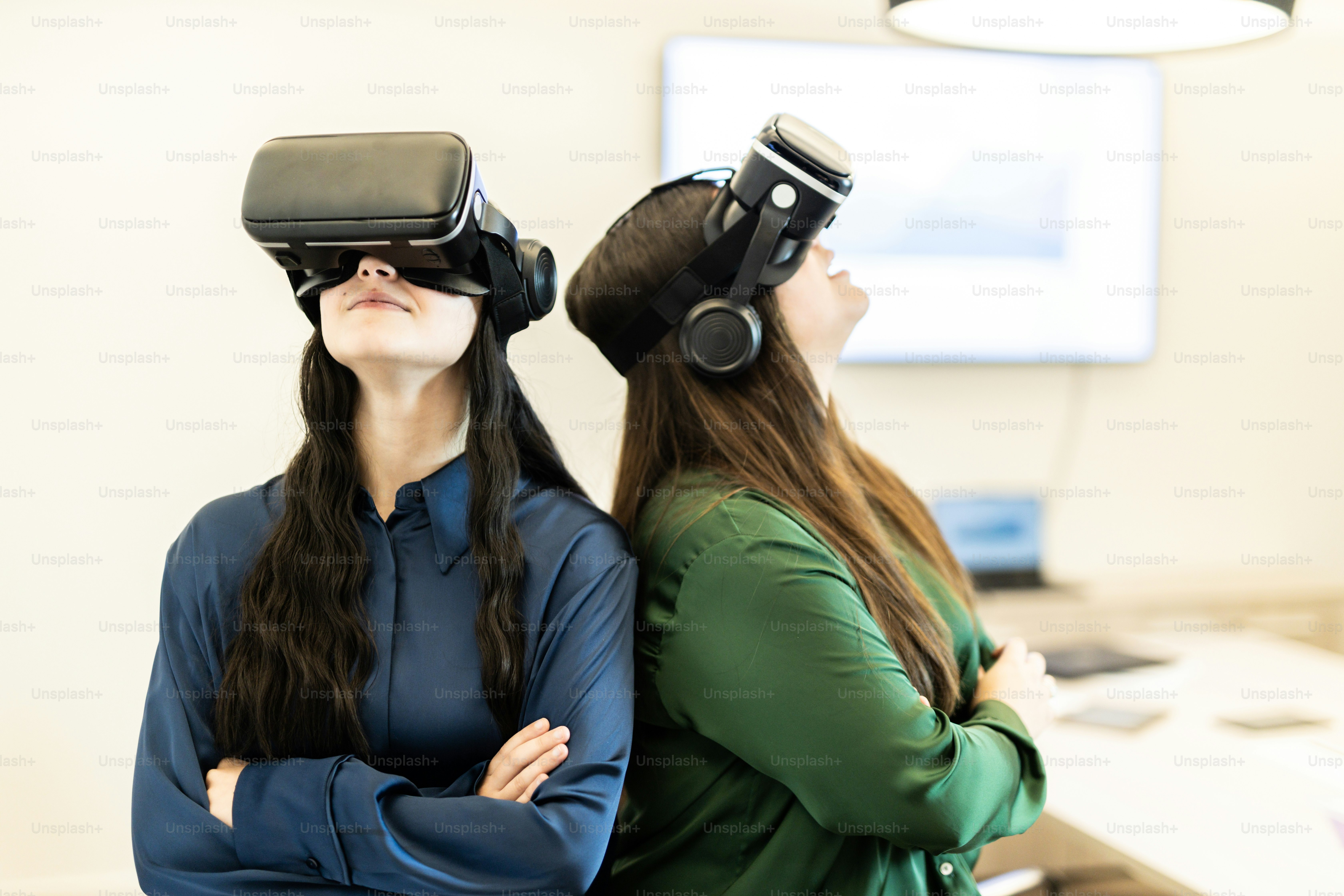 A group of women standing next to each other wearing virtual headsets ...