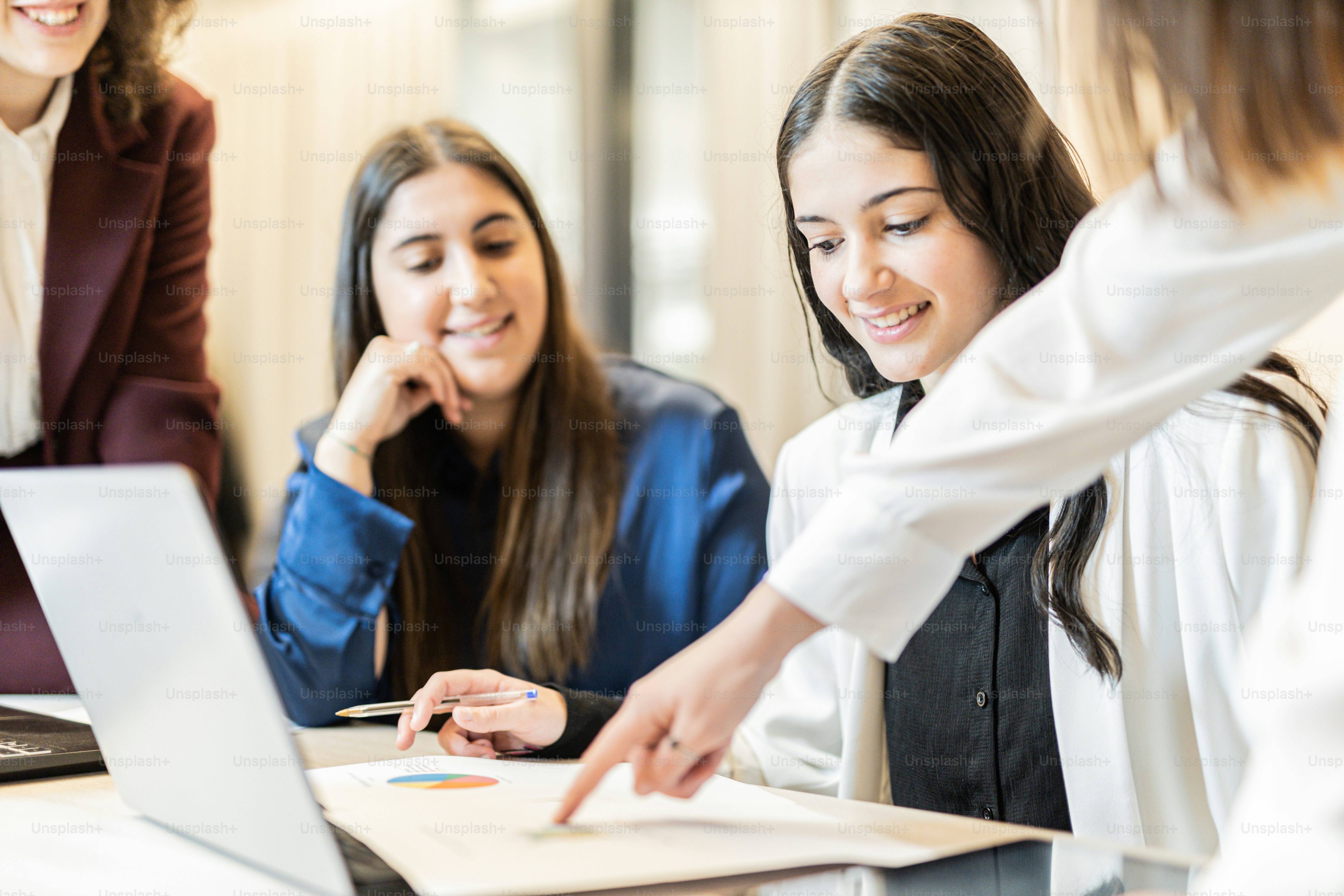 A group of women sitting around a laptop computer photo – Manager Image ...