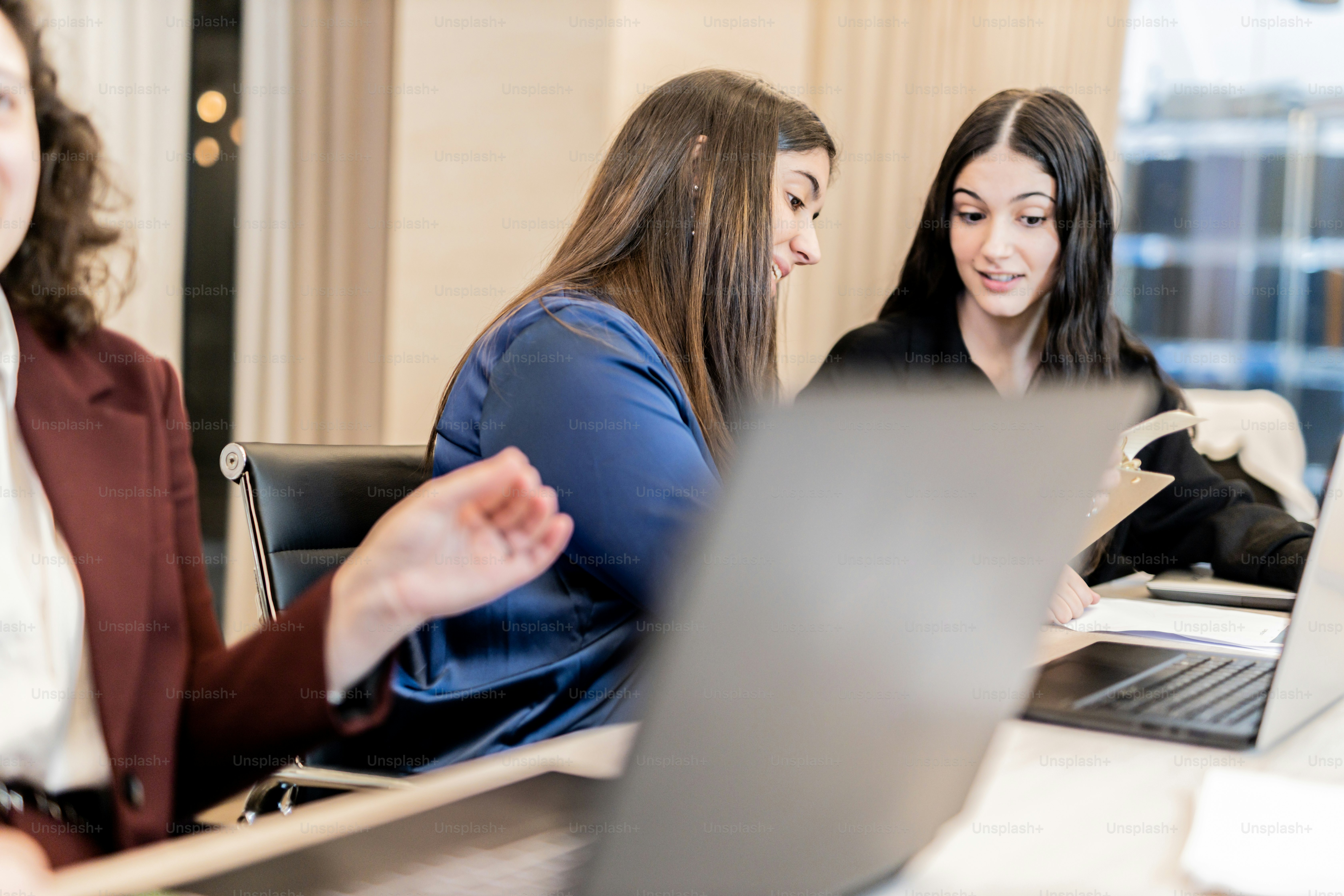 A group of women sitting around a laptop computer photo – Boardroom ...
