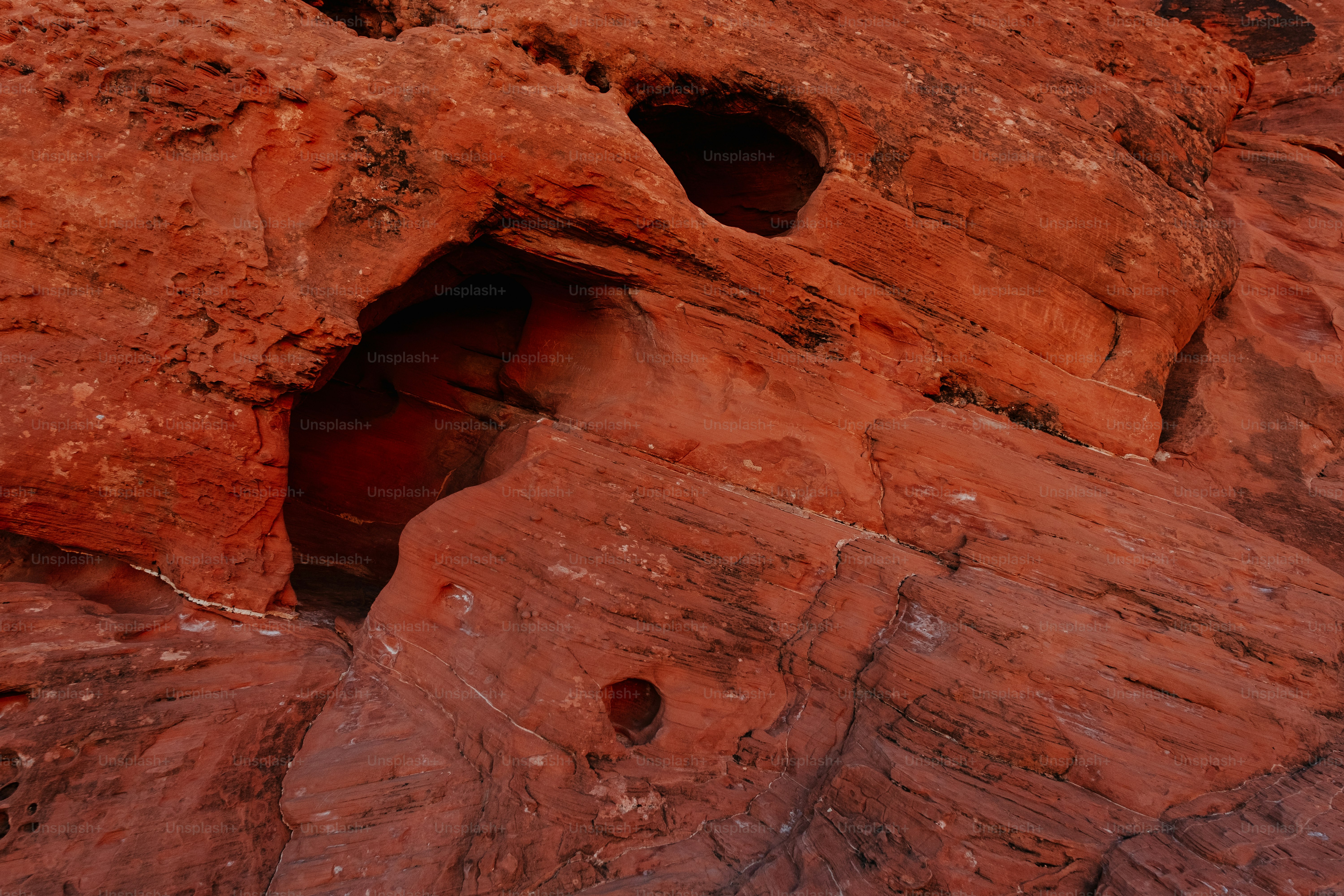 A rock formation with holes in the side of it photo – Mountain texture ...