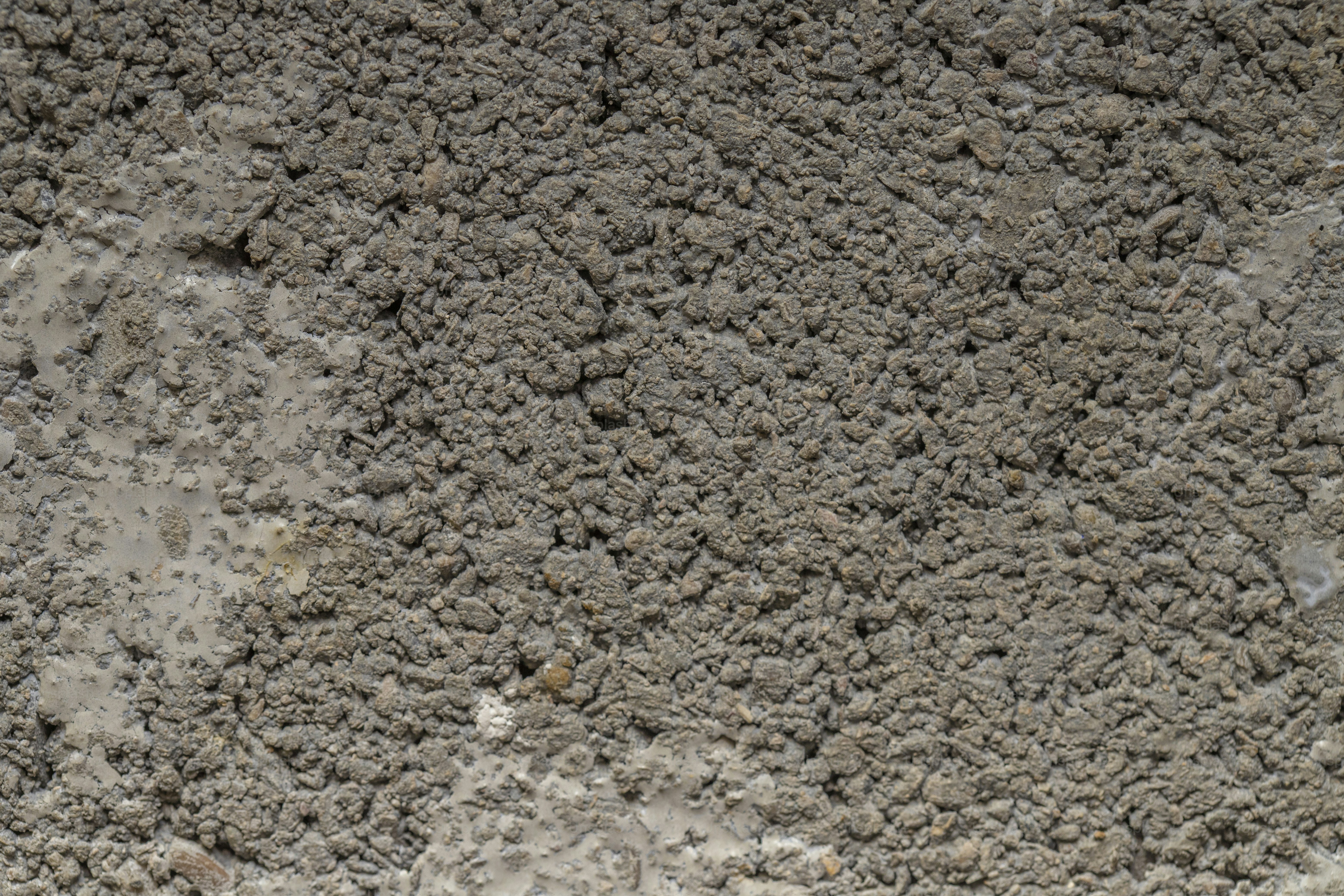 A close up of a cement wall with dirt on it photo – Stone Image on Unsplash