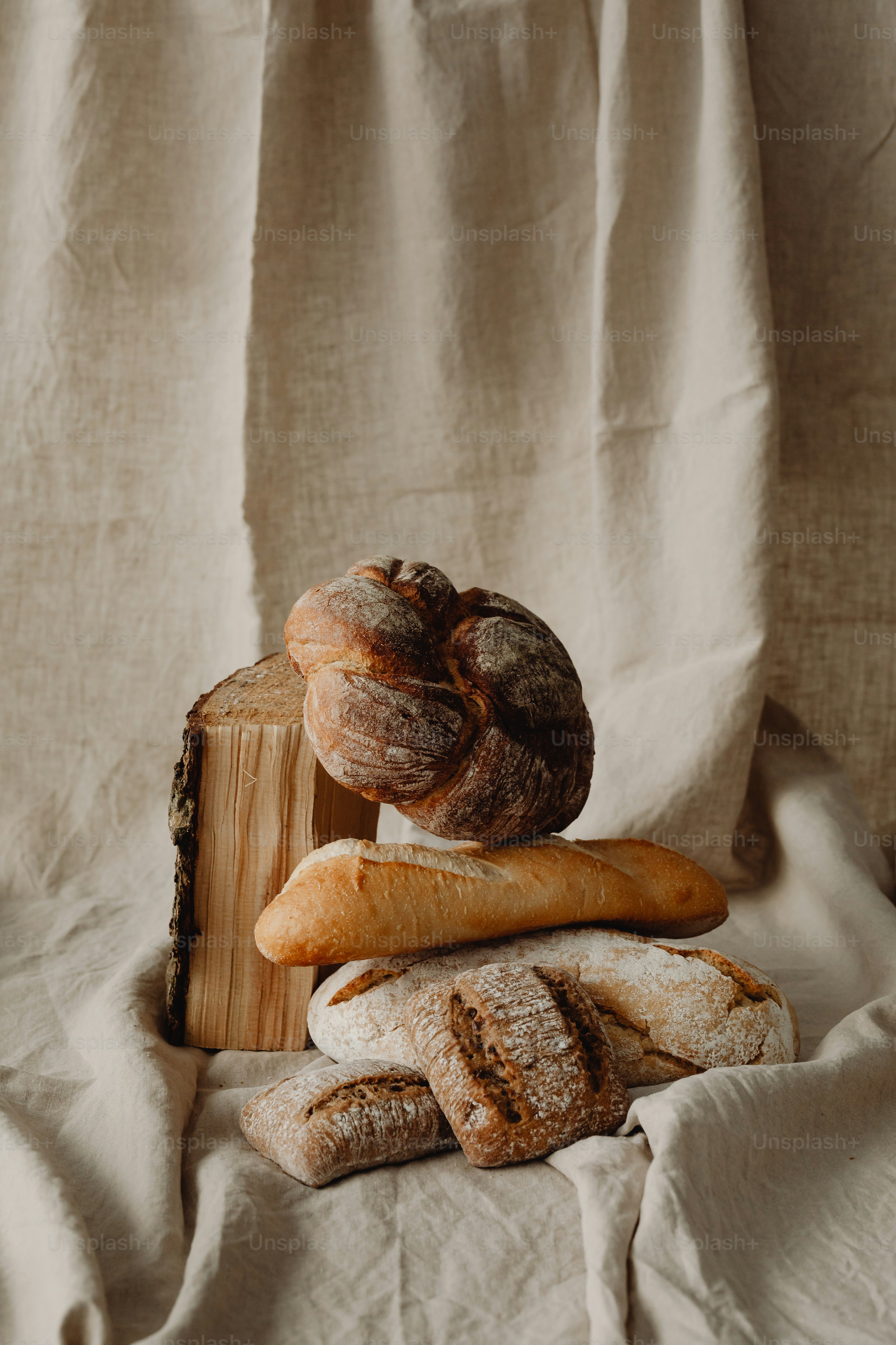 A pile of bread sitting on top of a wooden block photo – Bakery Image ...