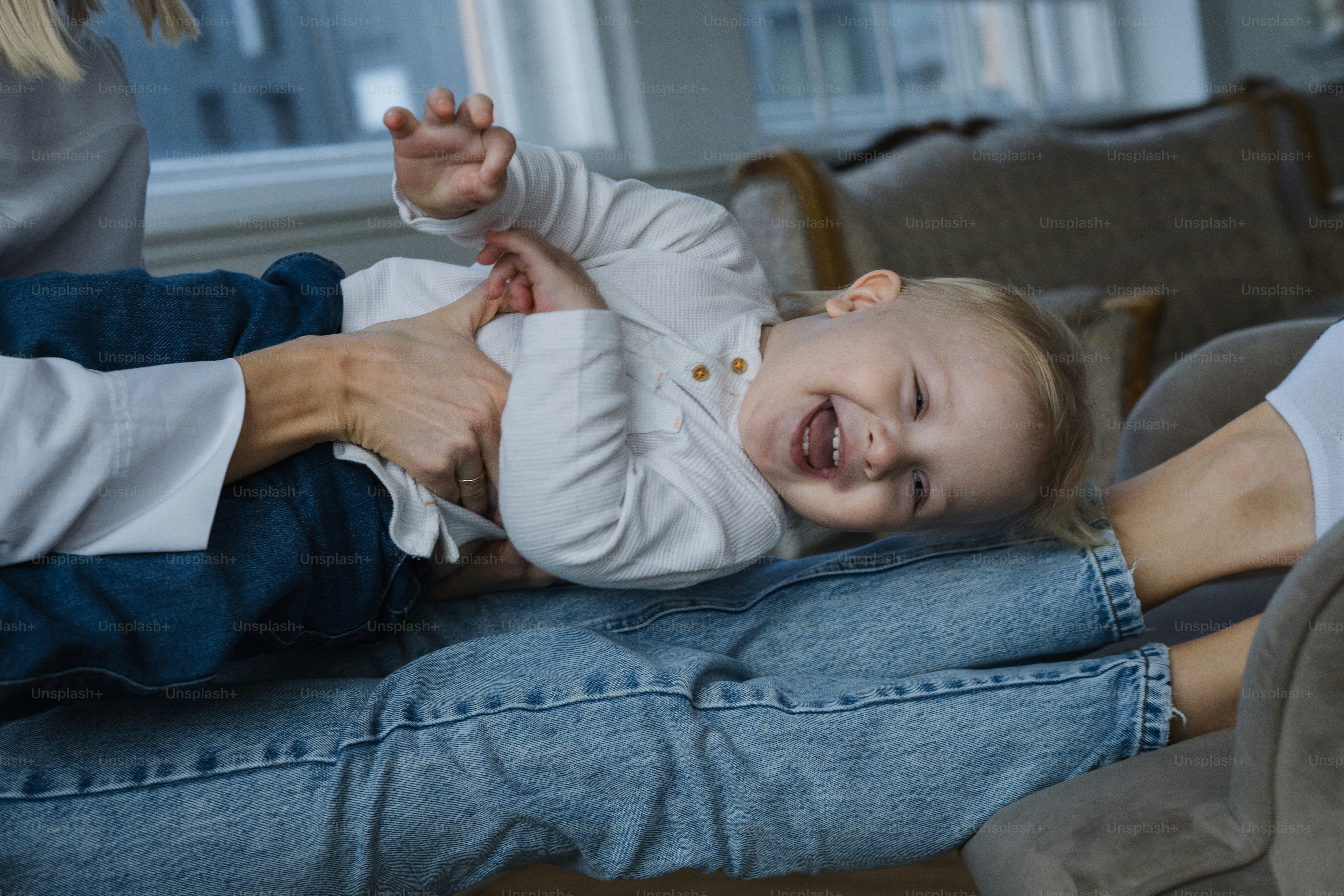 Foto Una mujer sosteniendo a un bebé en su regazo – Bebe riendo Imagen ...