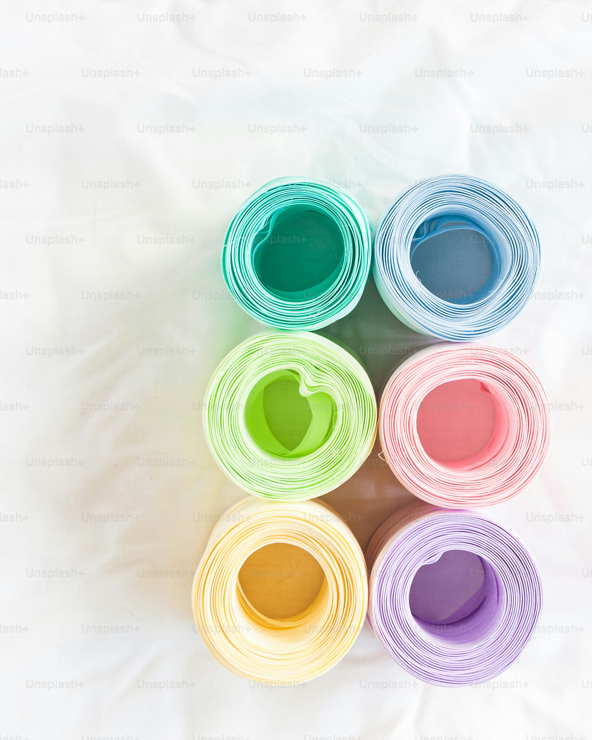 A group of rolled up paper sitting on top of a white sheet photo ...