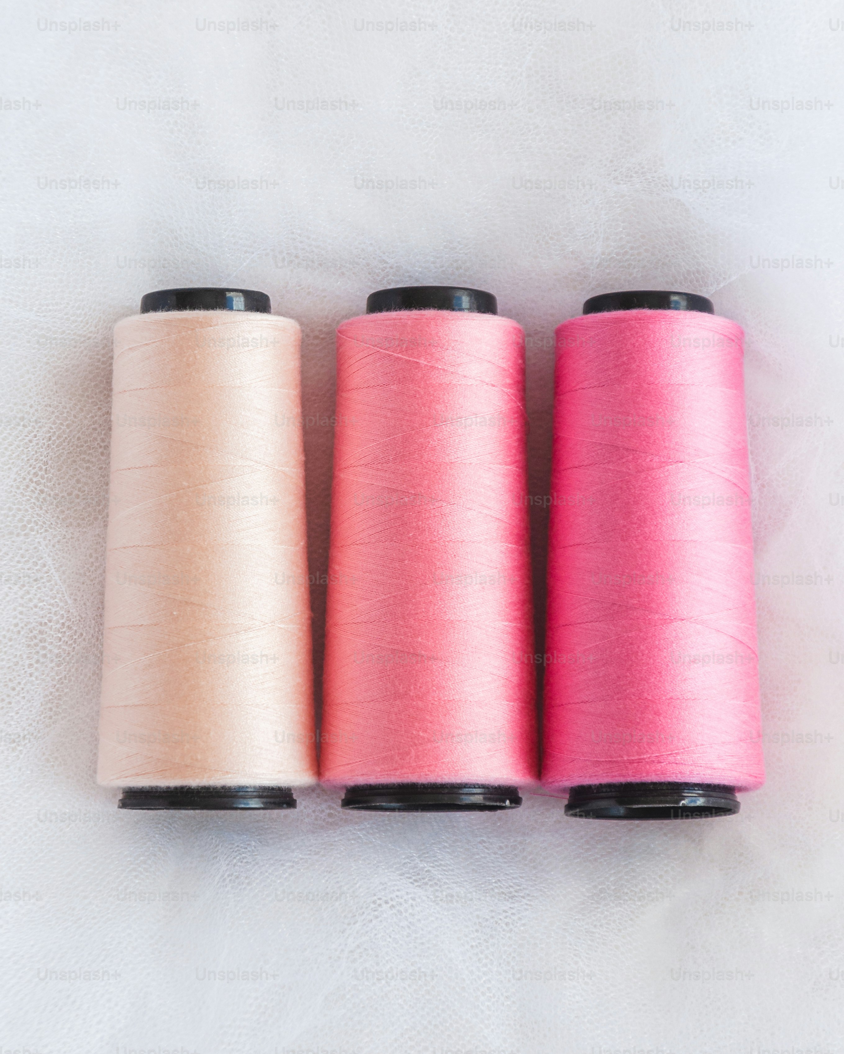 Three spools of thread sitting next to each other photo – Linen yarn ...