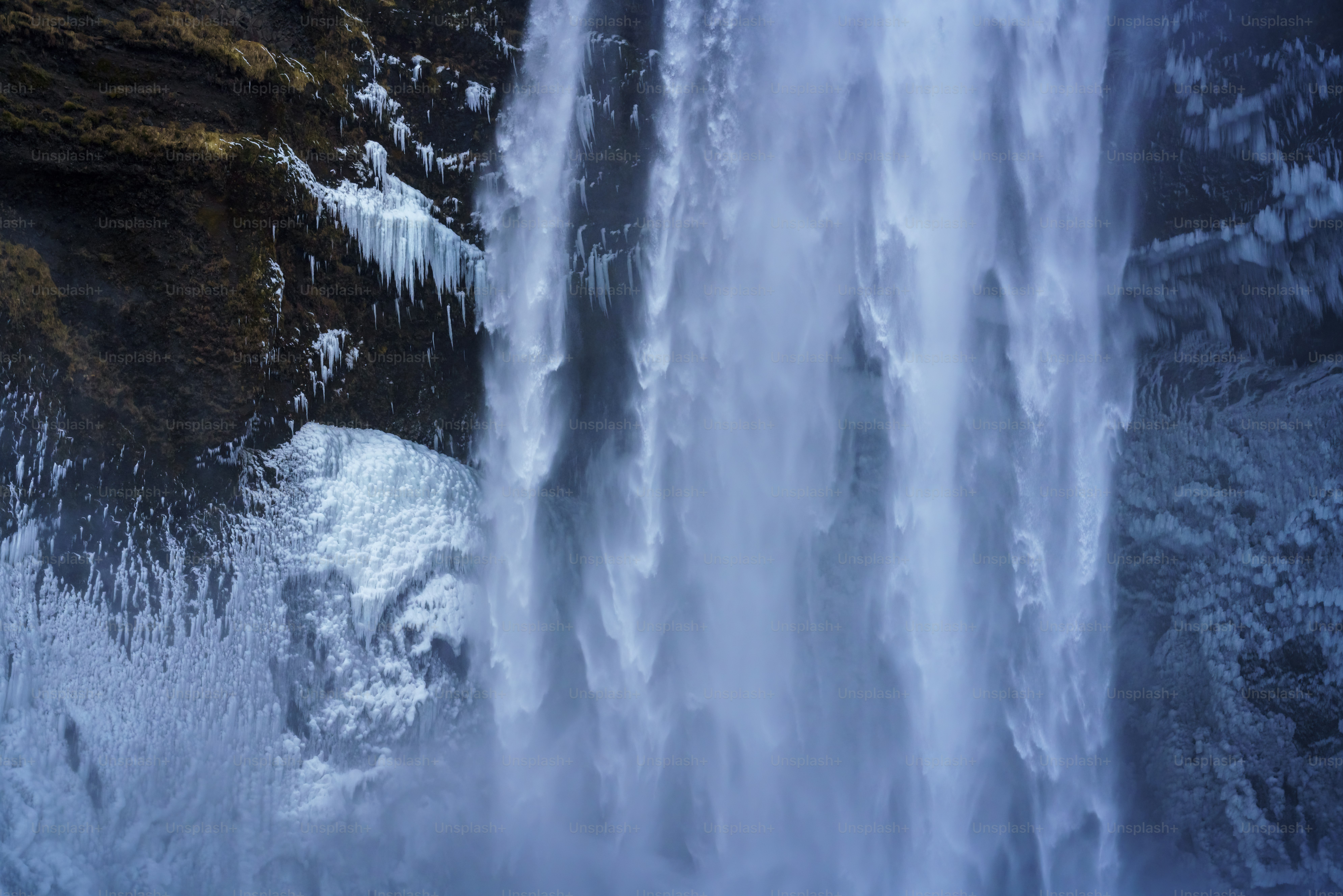 A large waterfall with ice on the side of it photo – Waterfall Image on ...