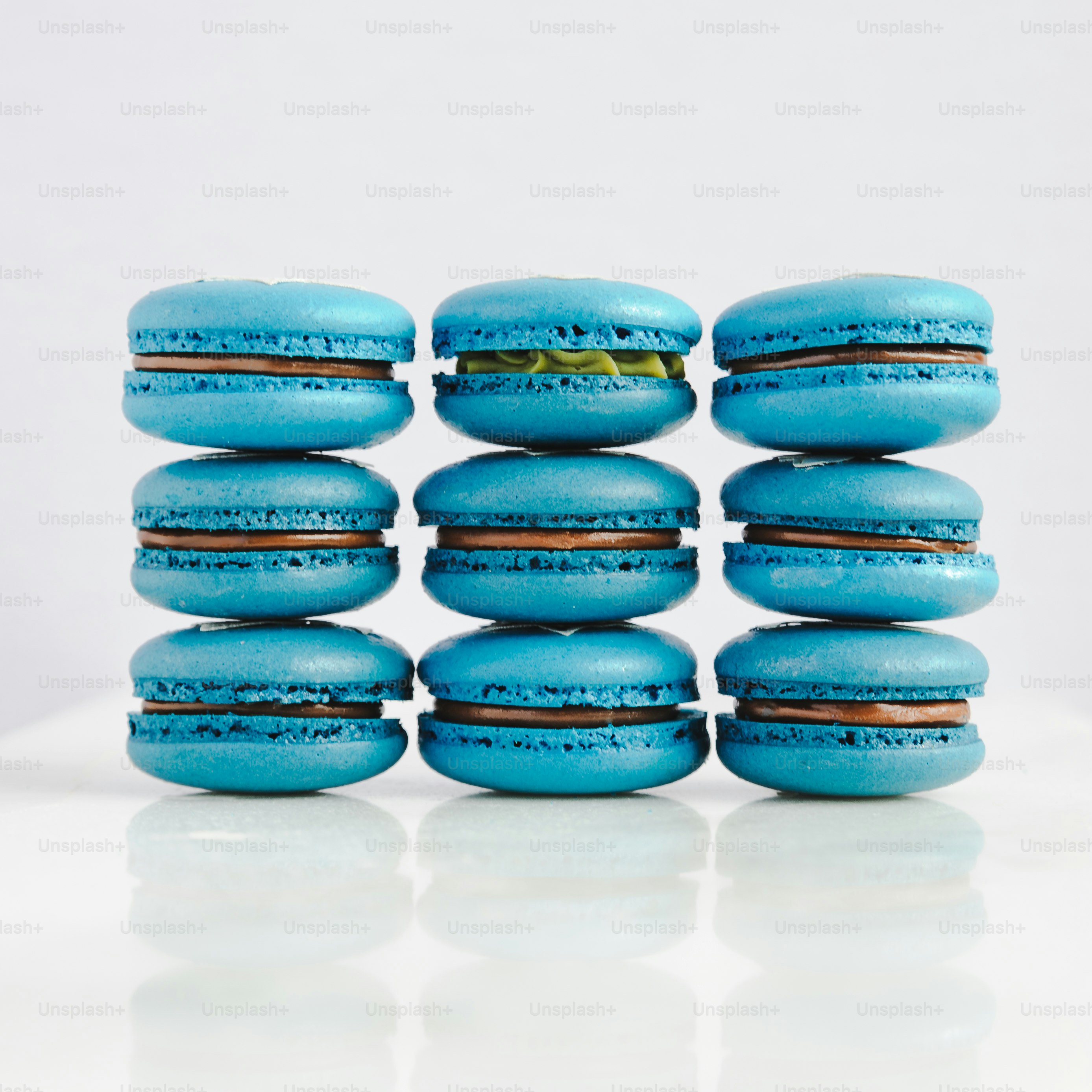 A stack of blue macaroons sitting on top of each other photo – Bakery ...