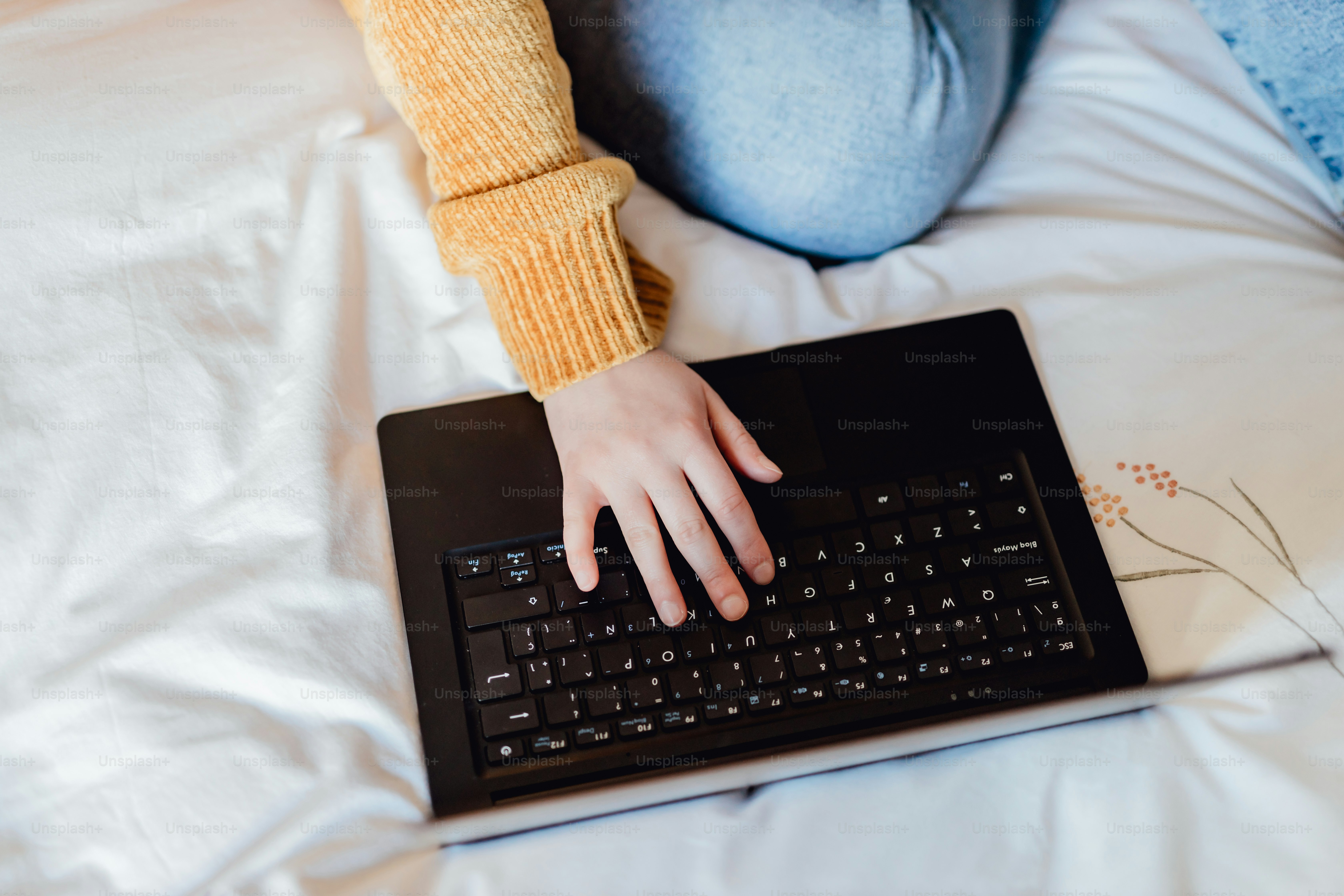 A woman sitting on a couch using a laptop computer photo – Laptop Image ...