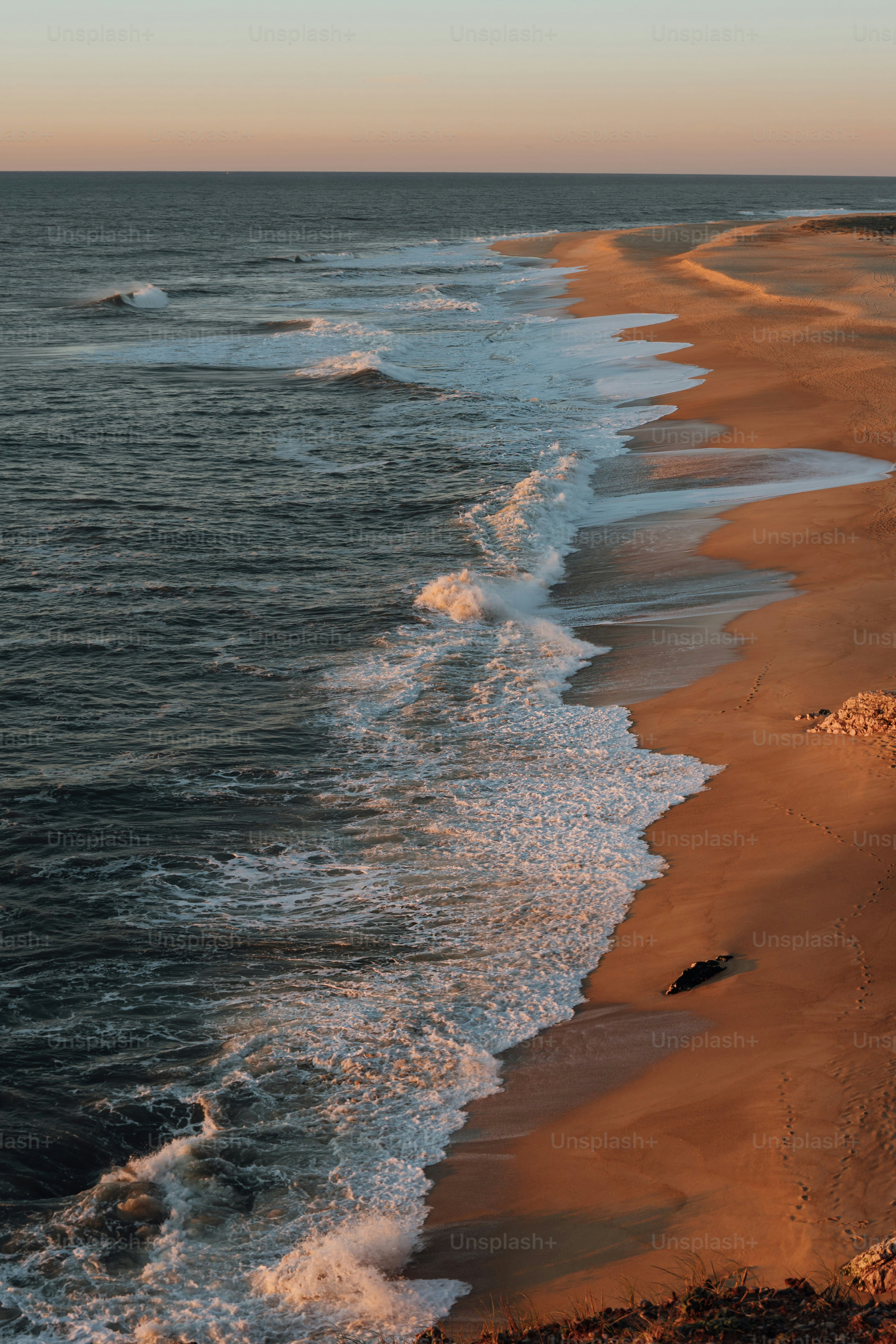 A view of a beach with waves coming in from the ocean photo – Waves ...