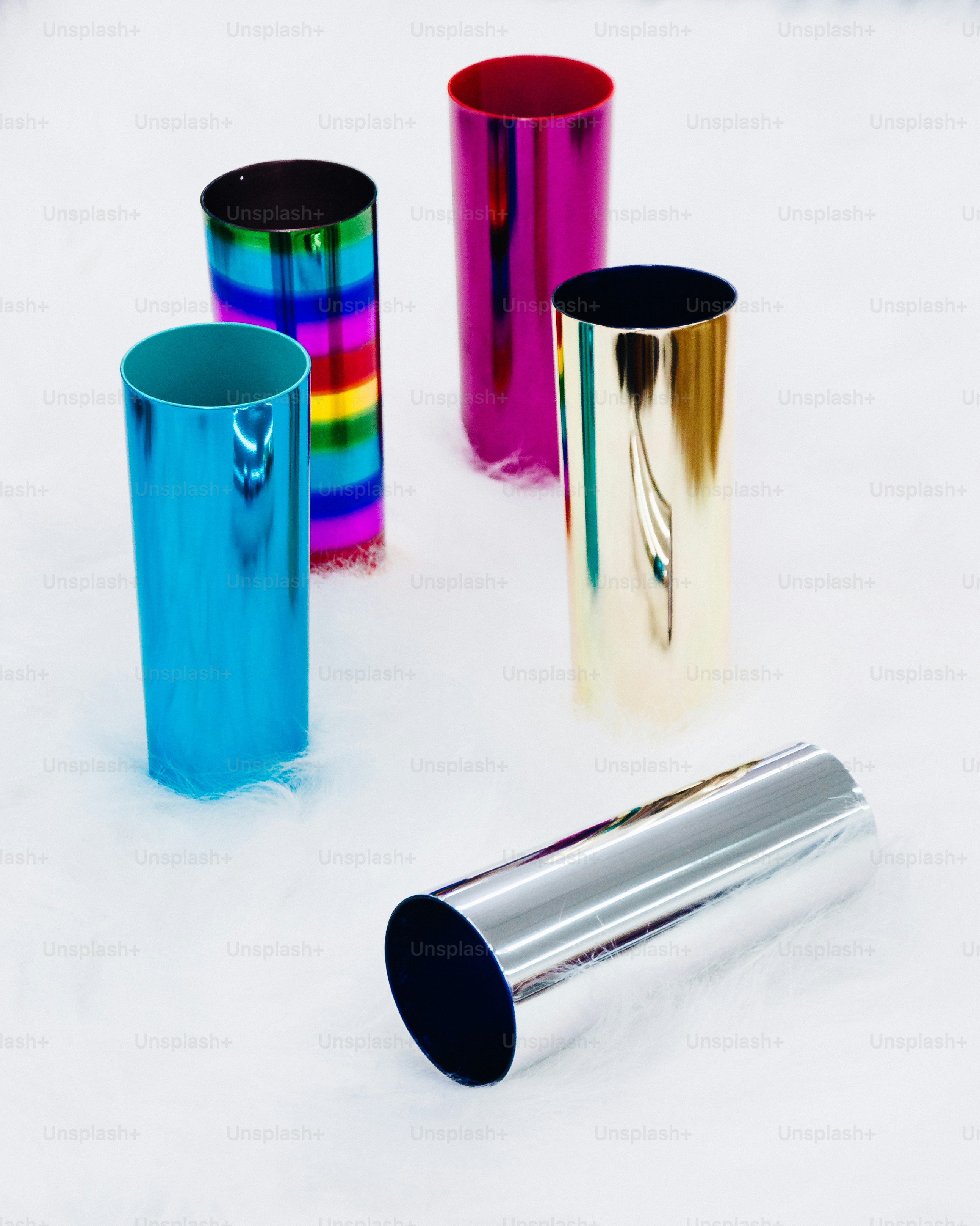 A group of different colored cups sitting on top of a snow covered ...