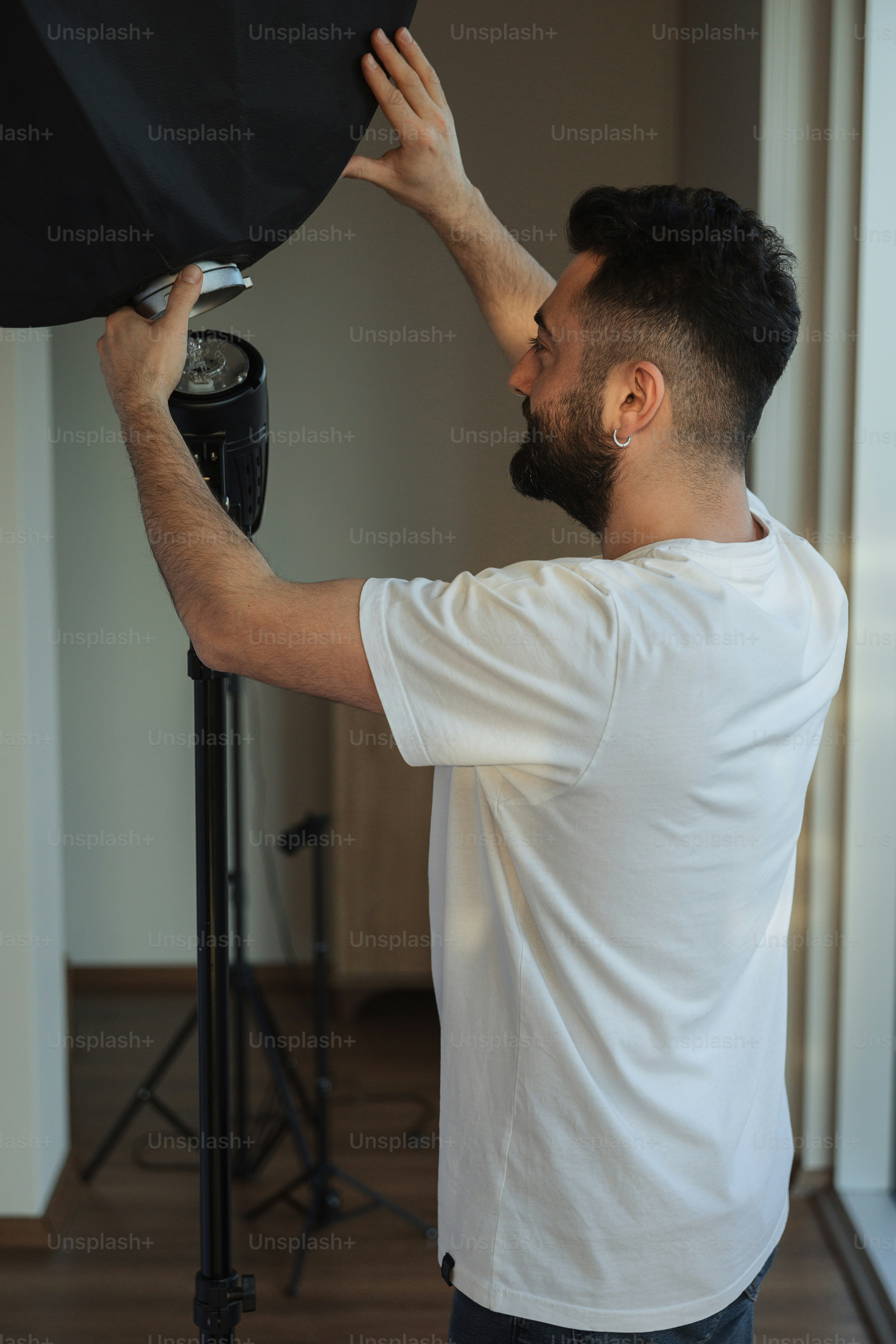 A man holding a black object up to his face photo – Camera Image on ...