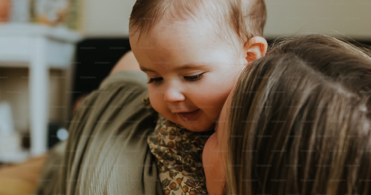 赤ん坊を抱えてベッドの上に横たわる女性の写真 母と子 Unsplashの写真