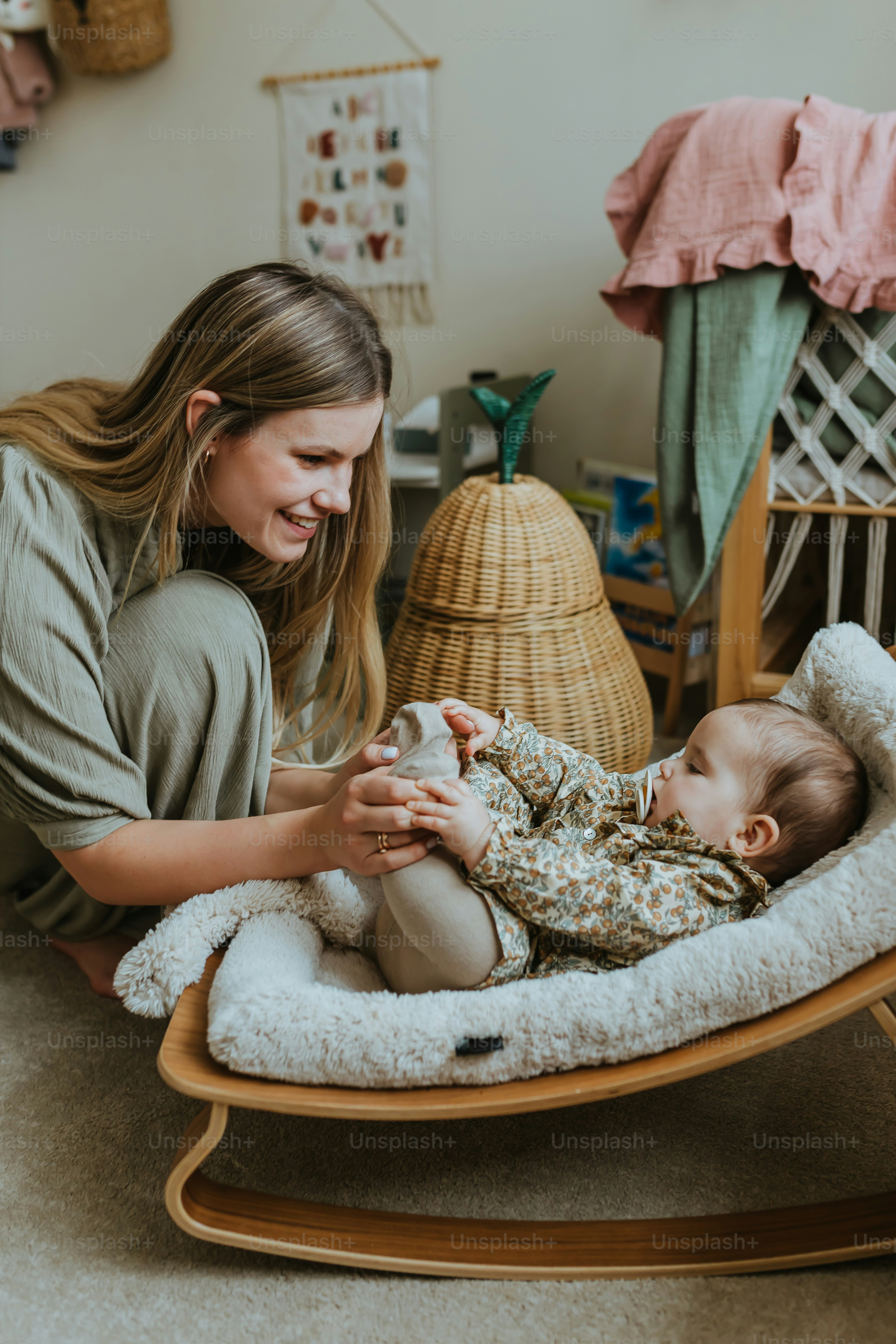A woman playing with a baby in a rocking chair photo – Family Image on ...