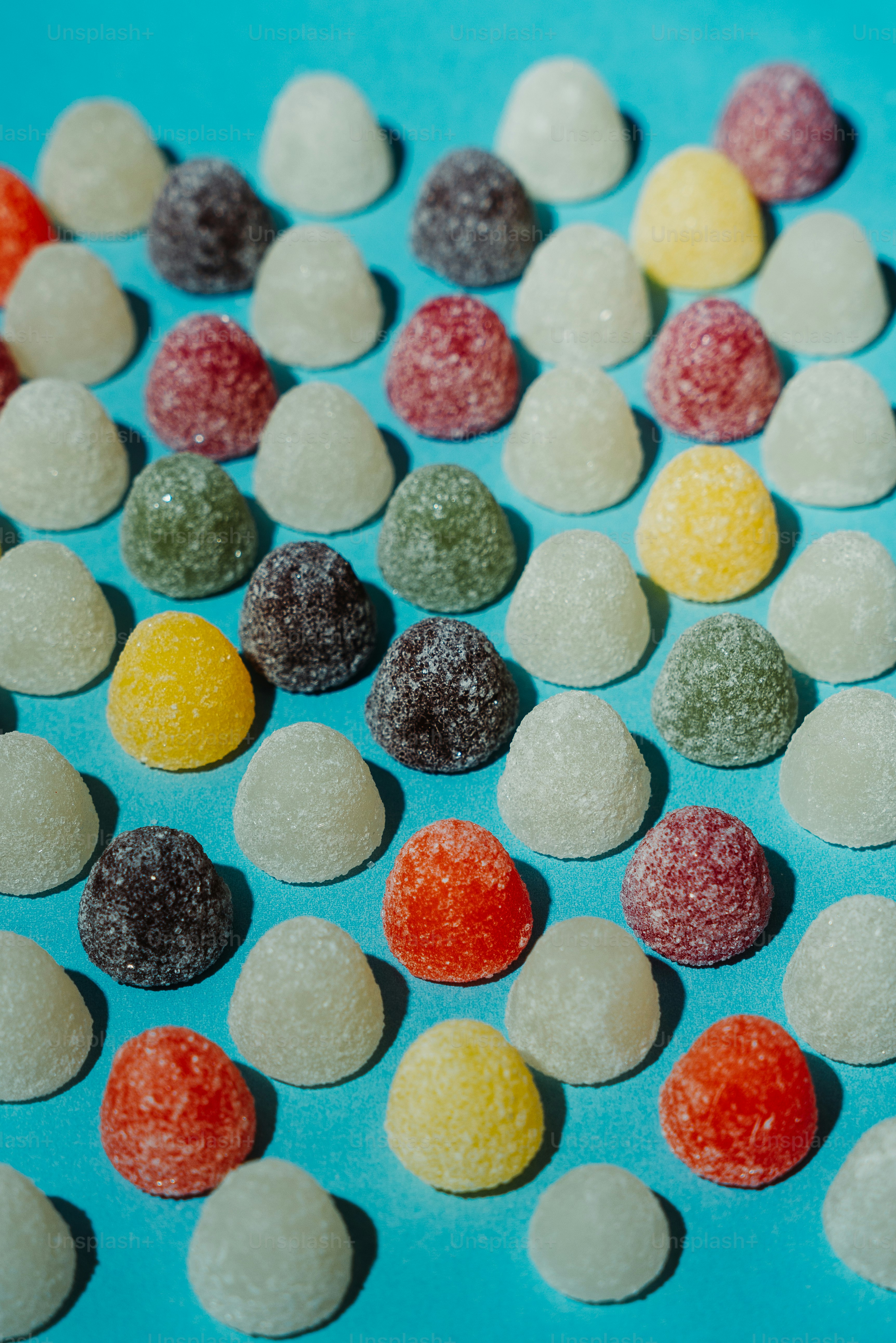 A bunch of different colored candies on a blue surface photo ...