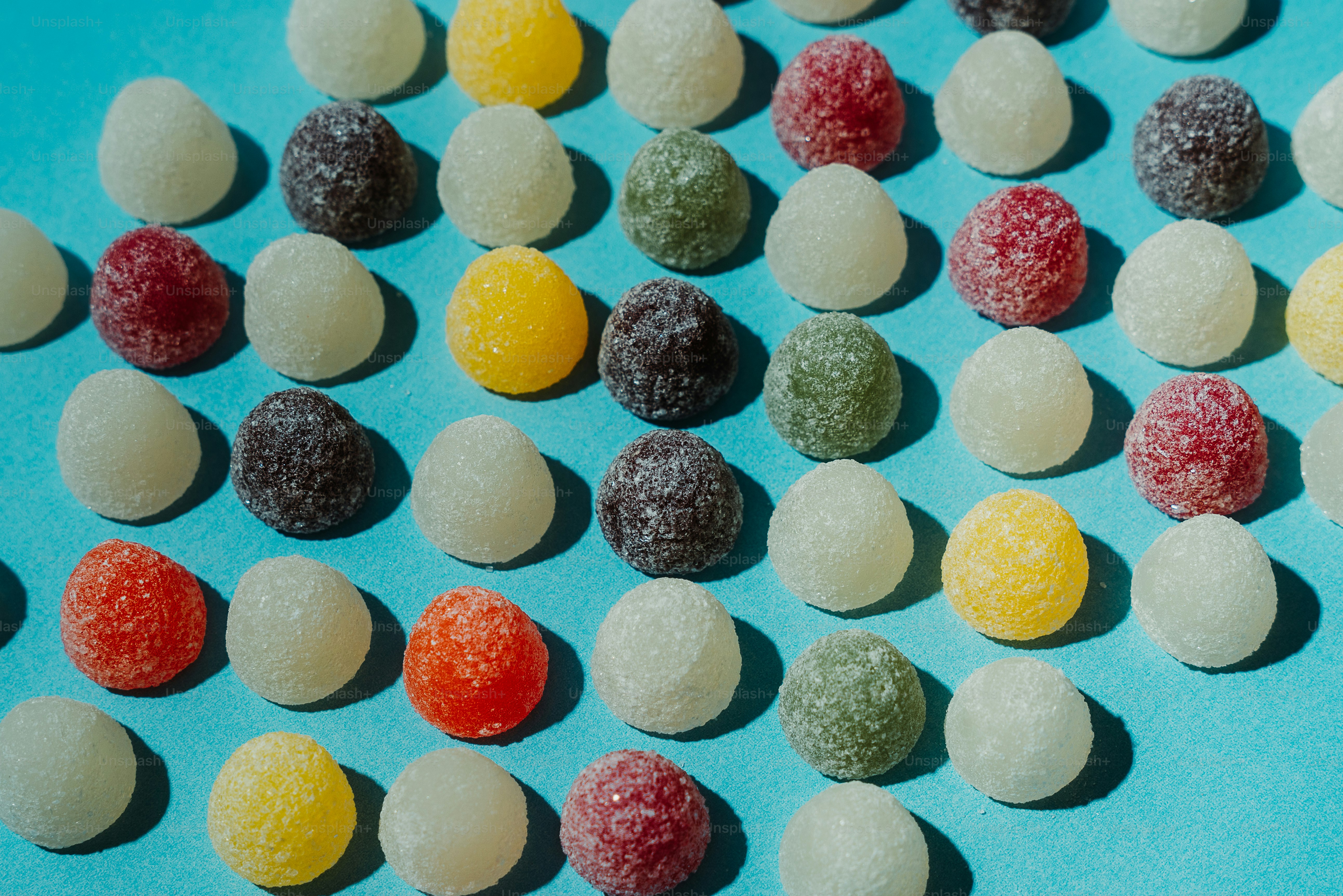 A group of candies sitting on top of a blue surface photo – Sweets ...